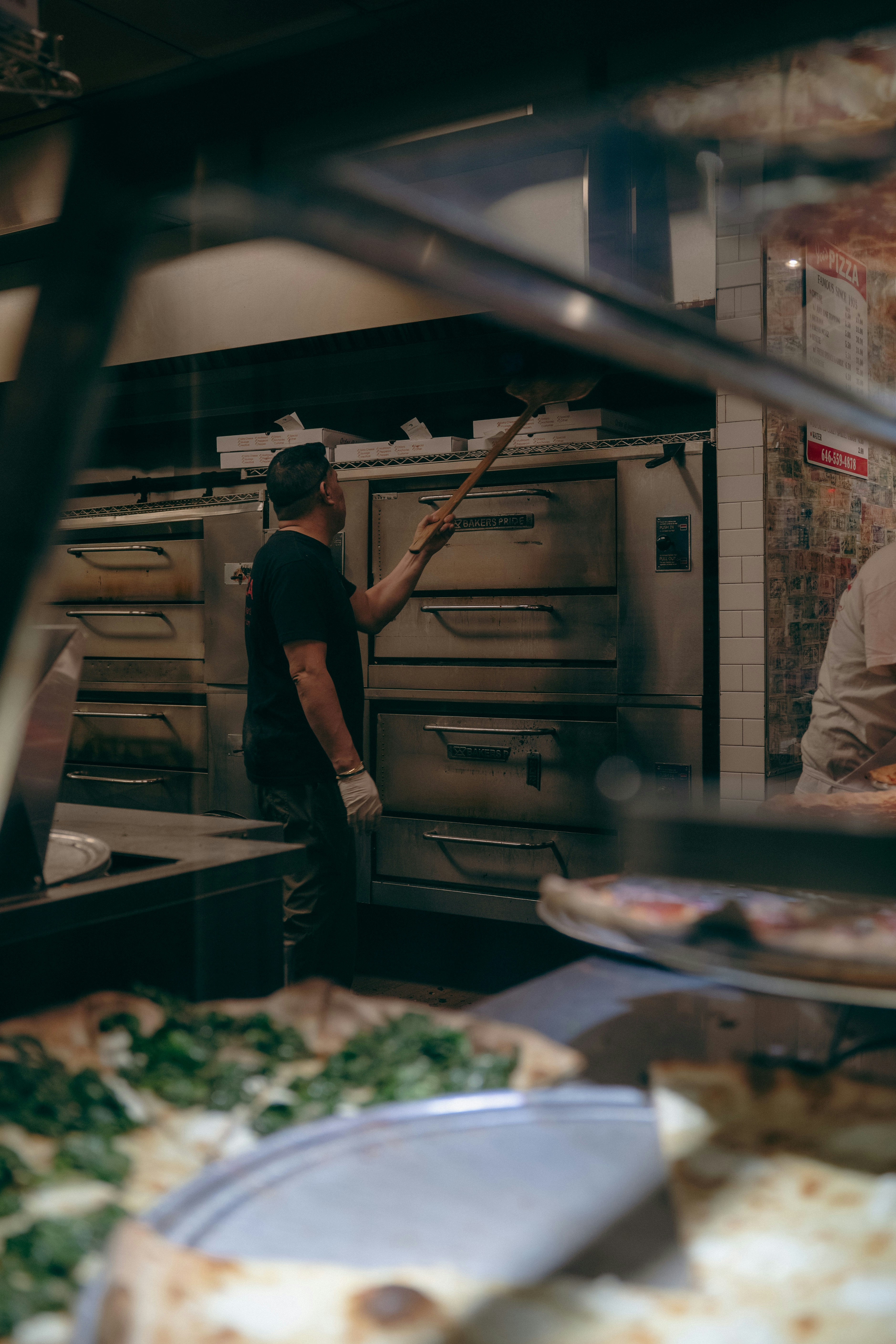 Midnight Prep: A Baker Prepares the Oven in a Busy Kitchen