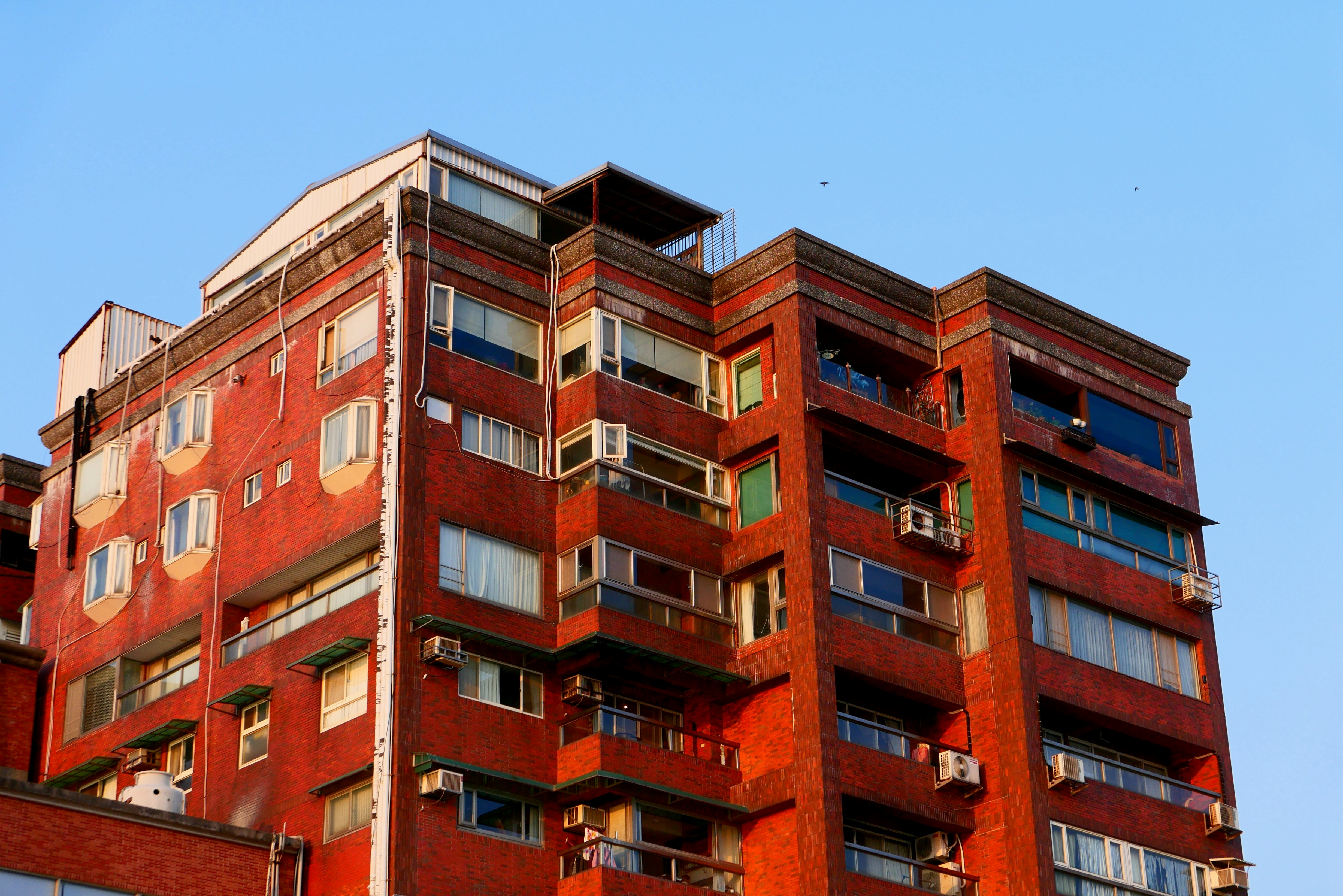 Red apartment building against a clear blue sky. photo – Free Building ...