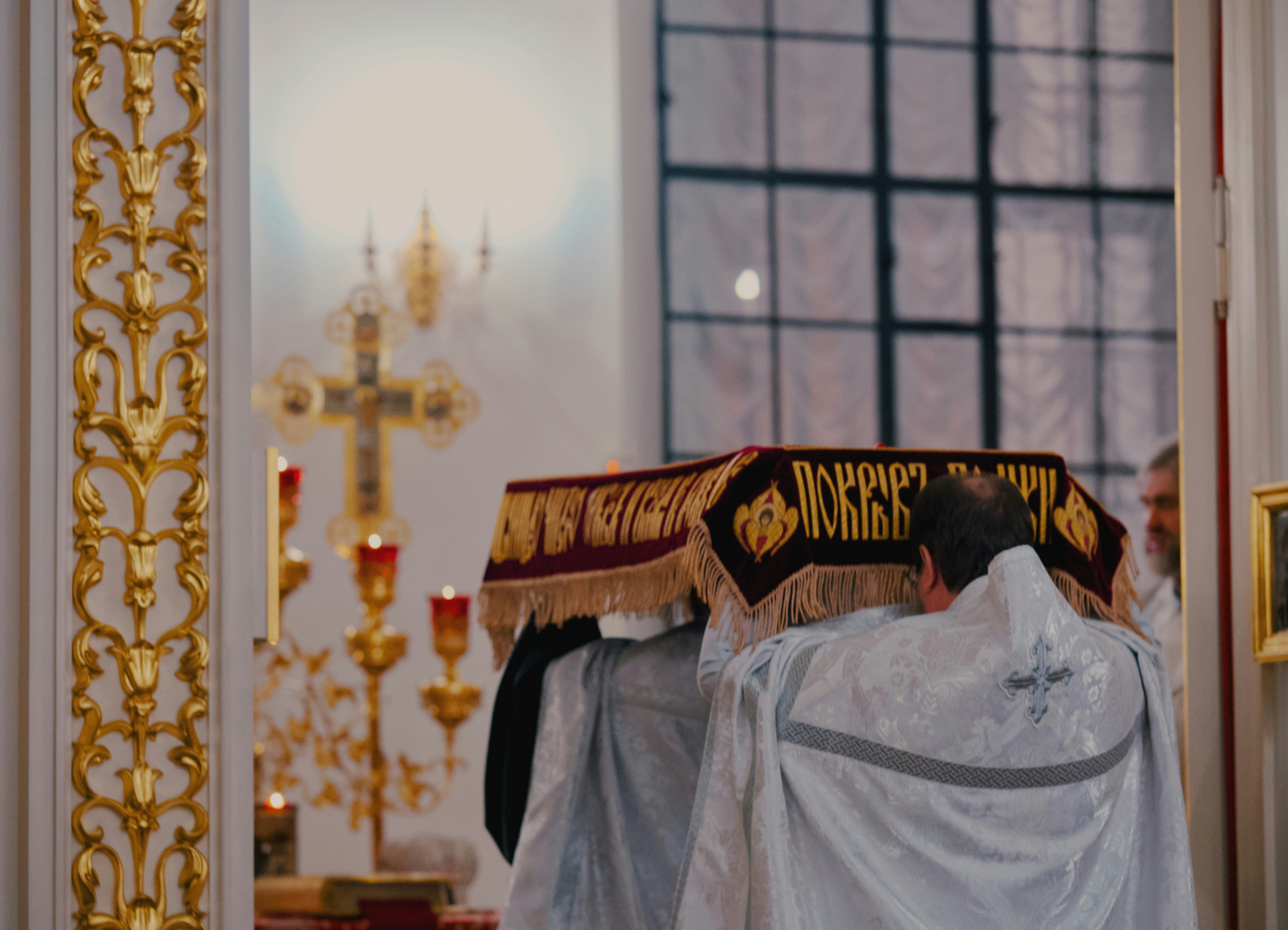 Clergy members carry a decorated casket in a church. photo – Free Woman ...