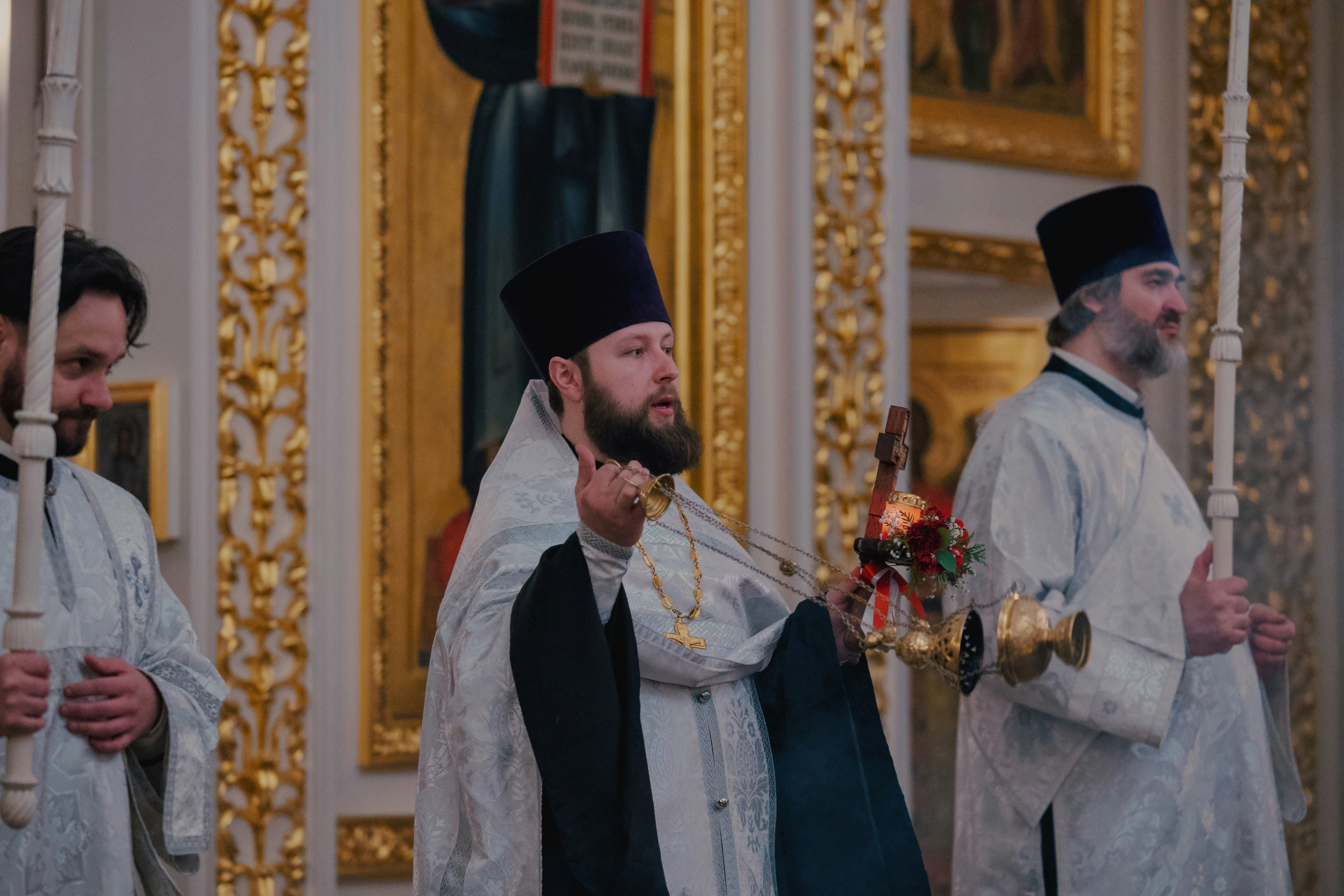Mid-Procession Under Golden Arches: Orthodox Clergy in Silent Ceremony