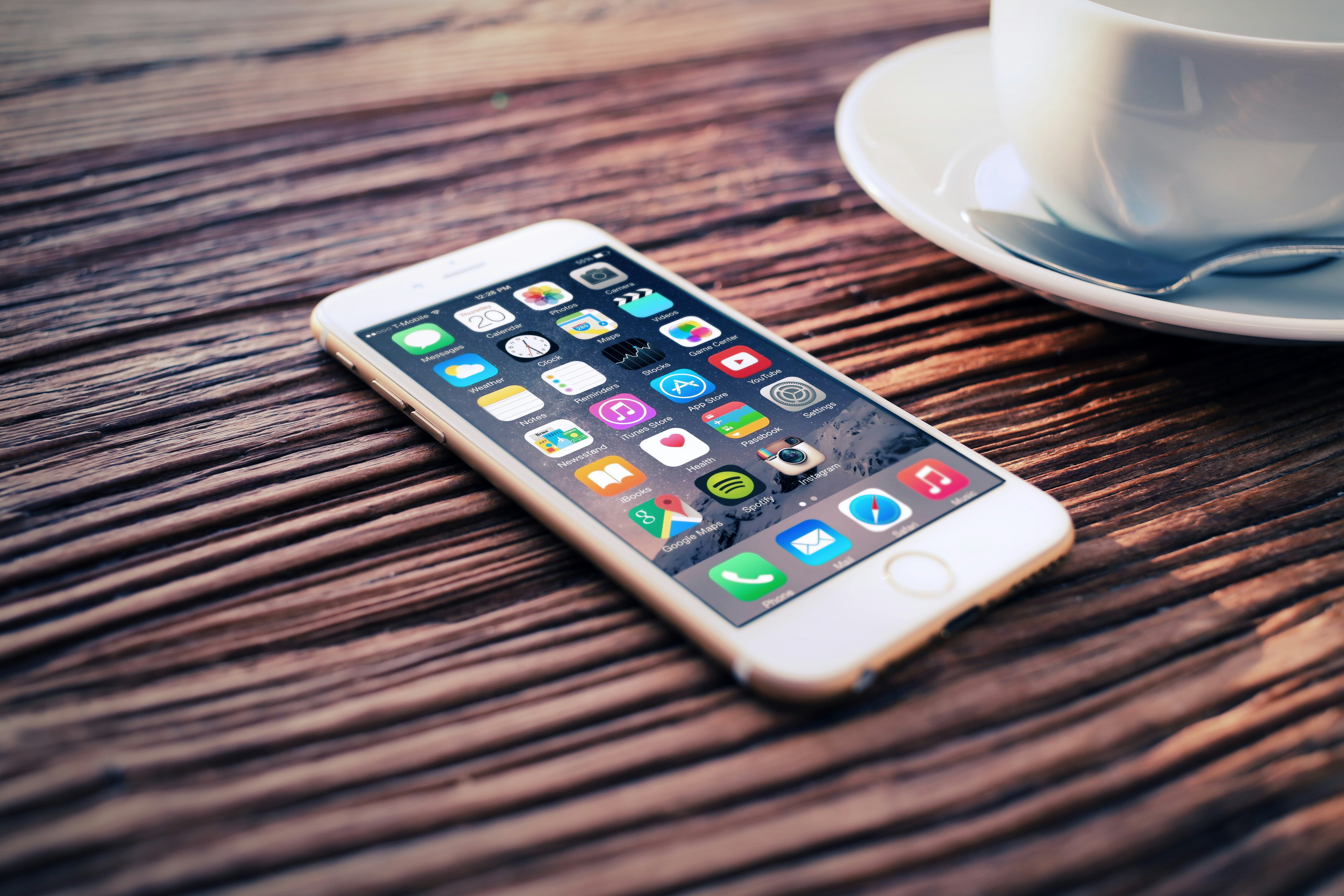A phone and coffee cup rest on a table. photo – Free Technology Image ...