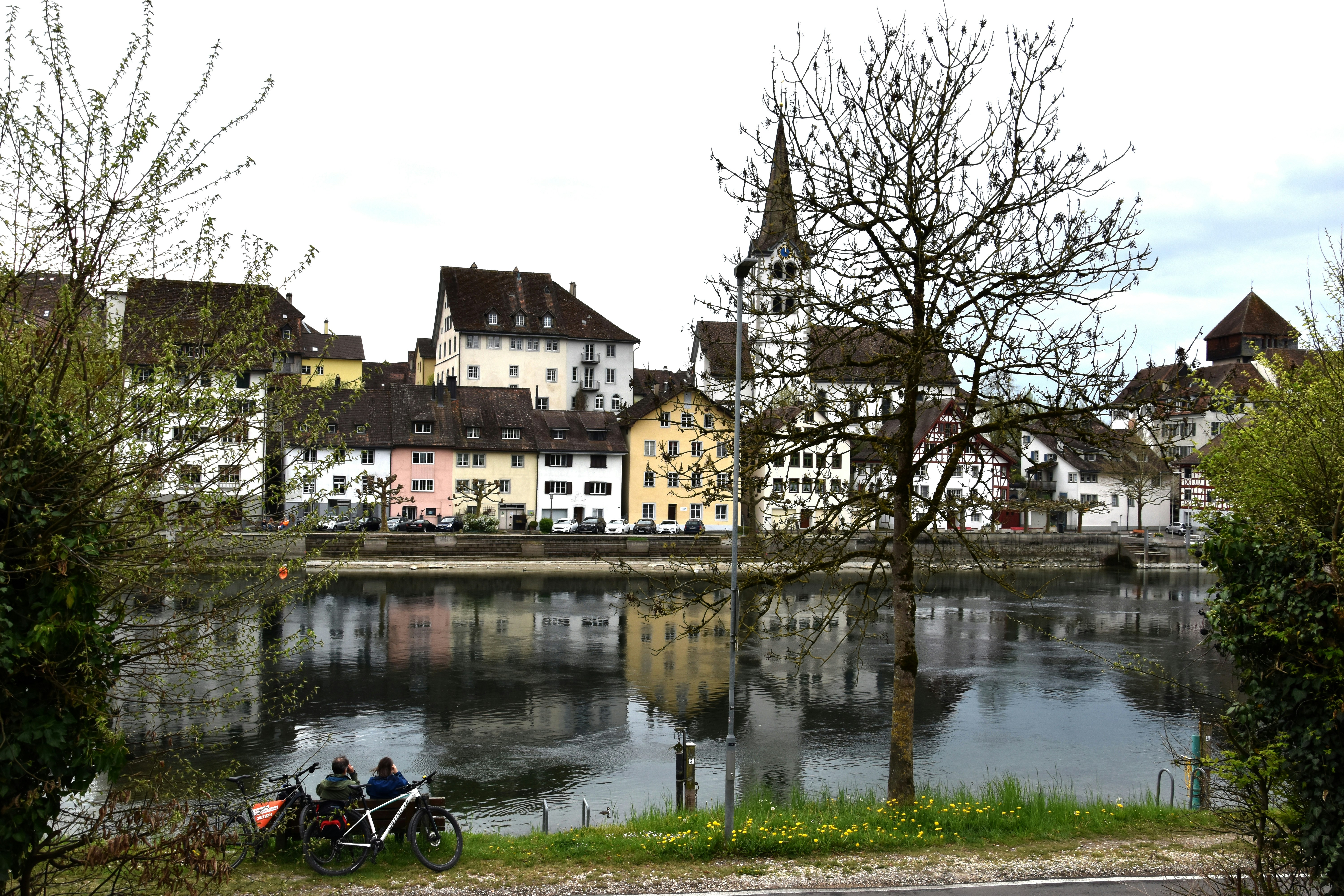 Buildings line a river, reflecting in the water. photo – Free ...