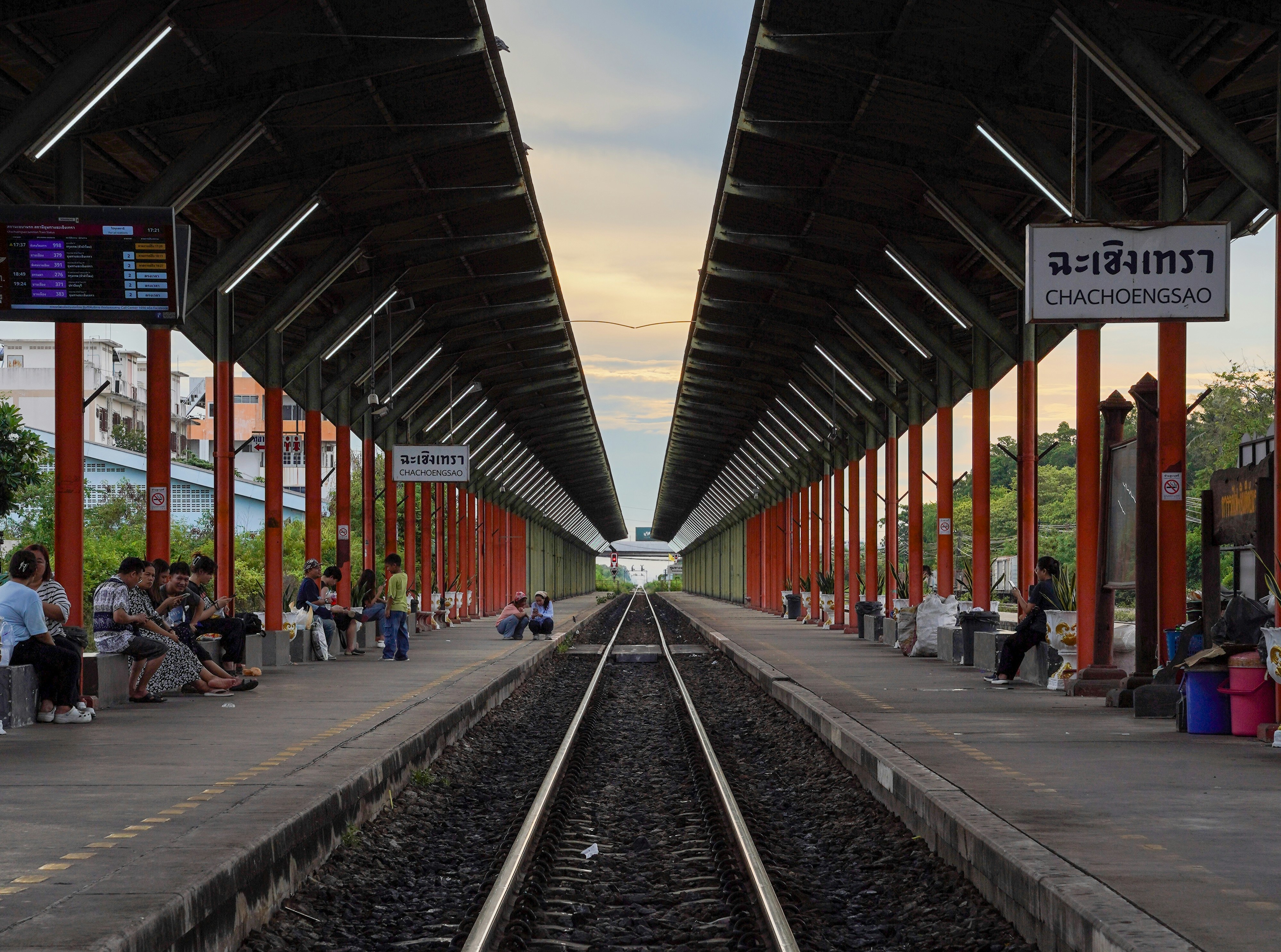A train station with tracks and waiting passengers. photo – Free Human ...