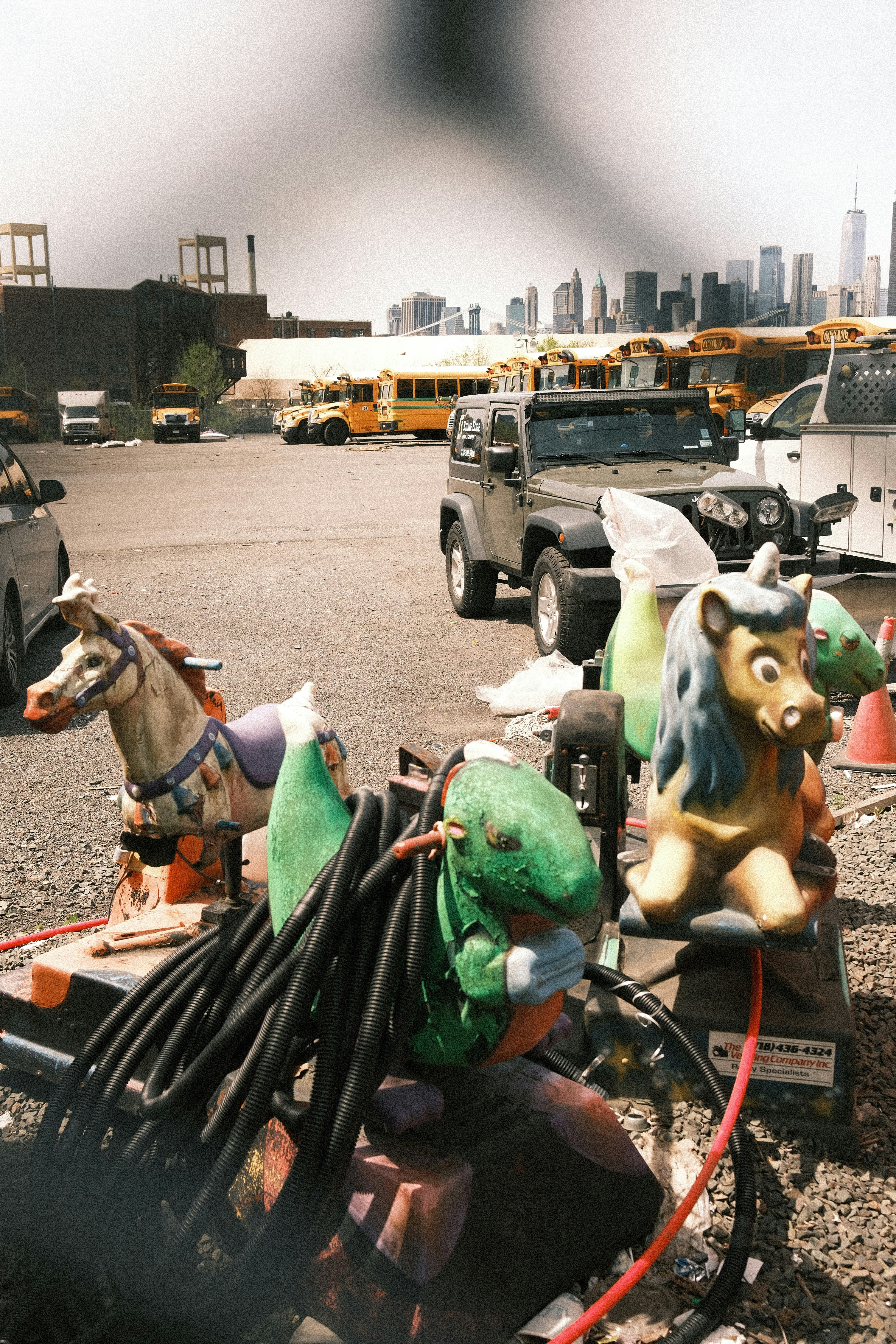 Colorful Ride-On Toys in a Bus Yard with a Distant Skyline