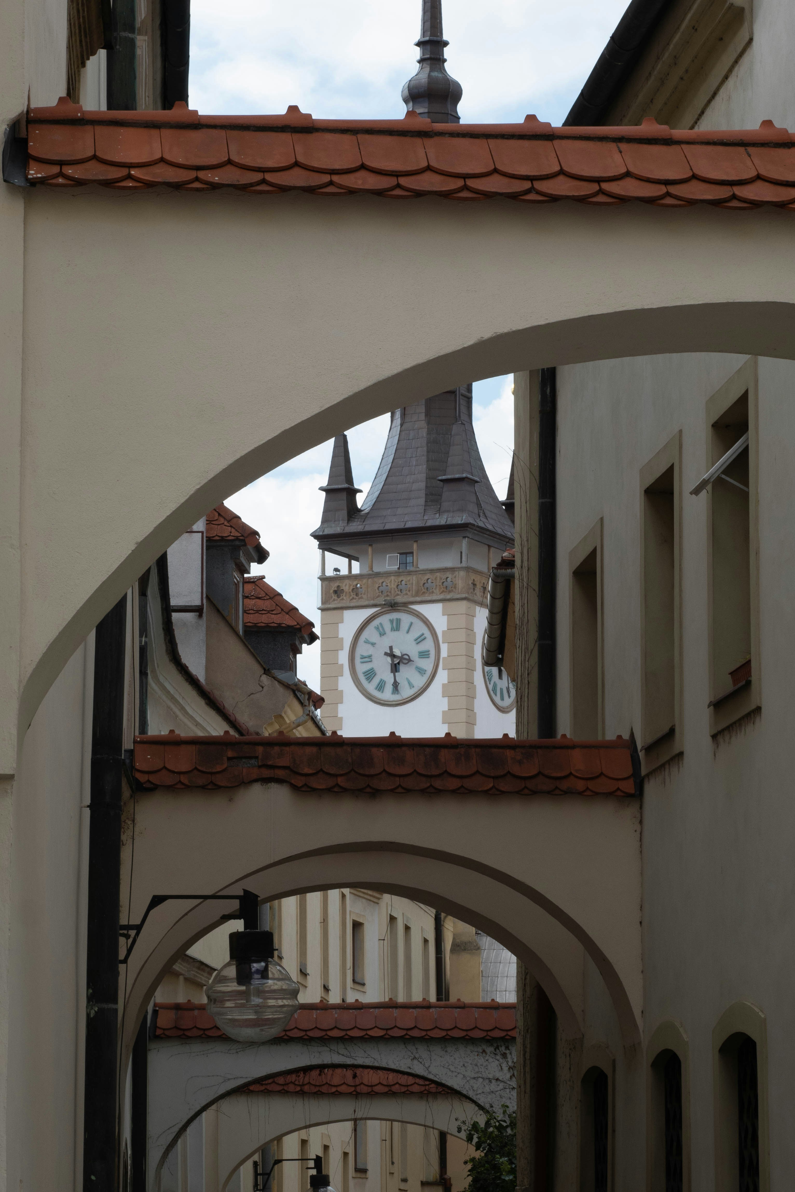 Arches frame a distant clock tower and buildings. photo – Free Building ...