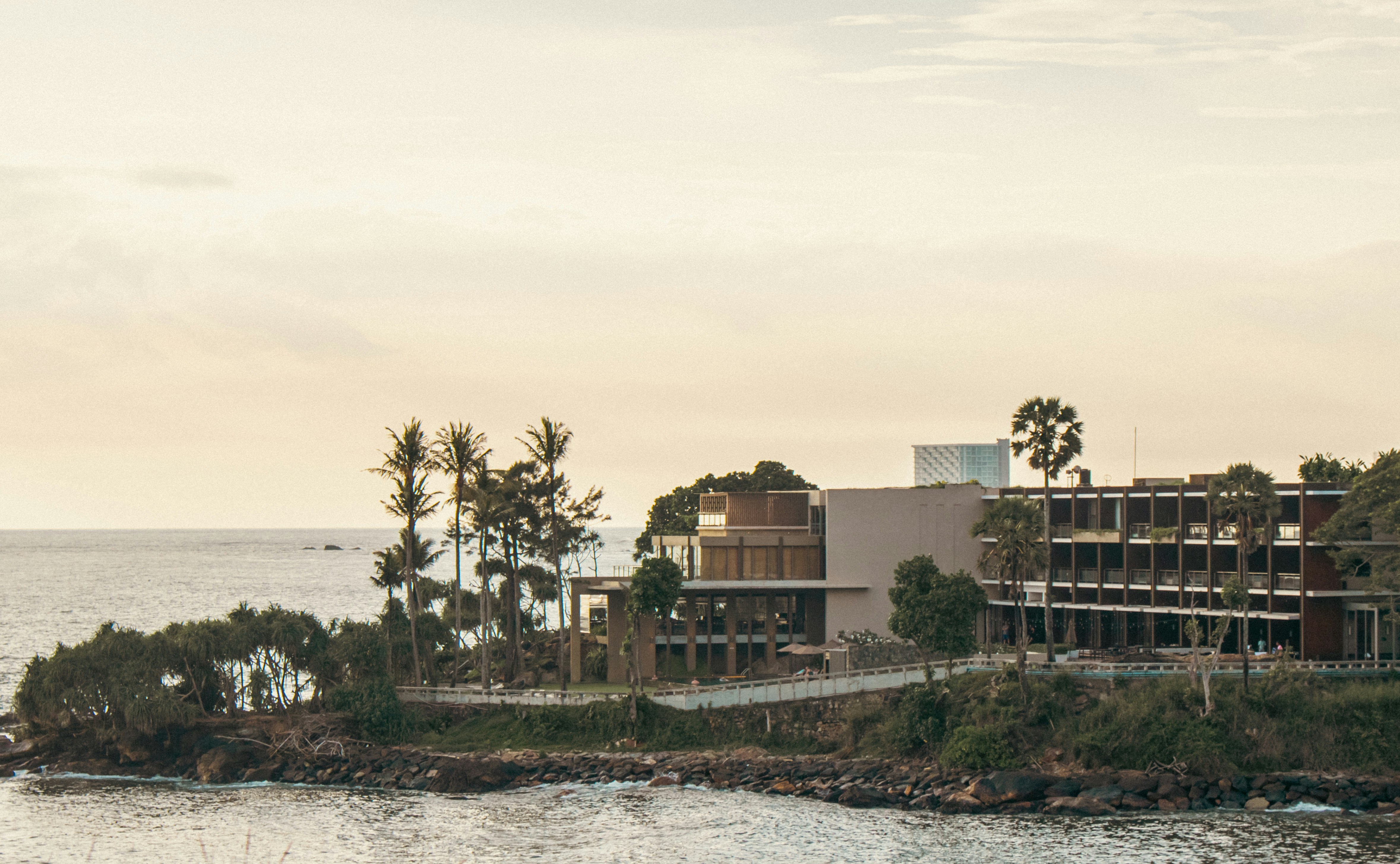 A modern hotel stands beside the ocean. photo – Free Travel Image on ...