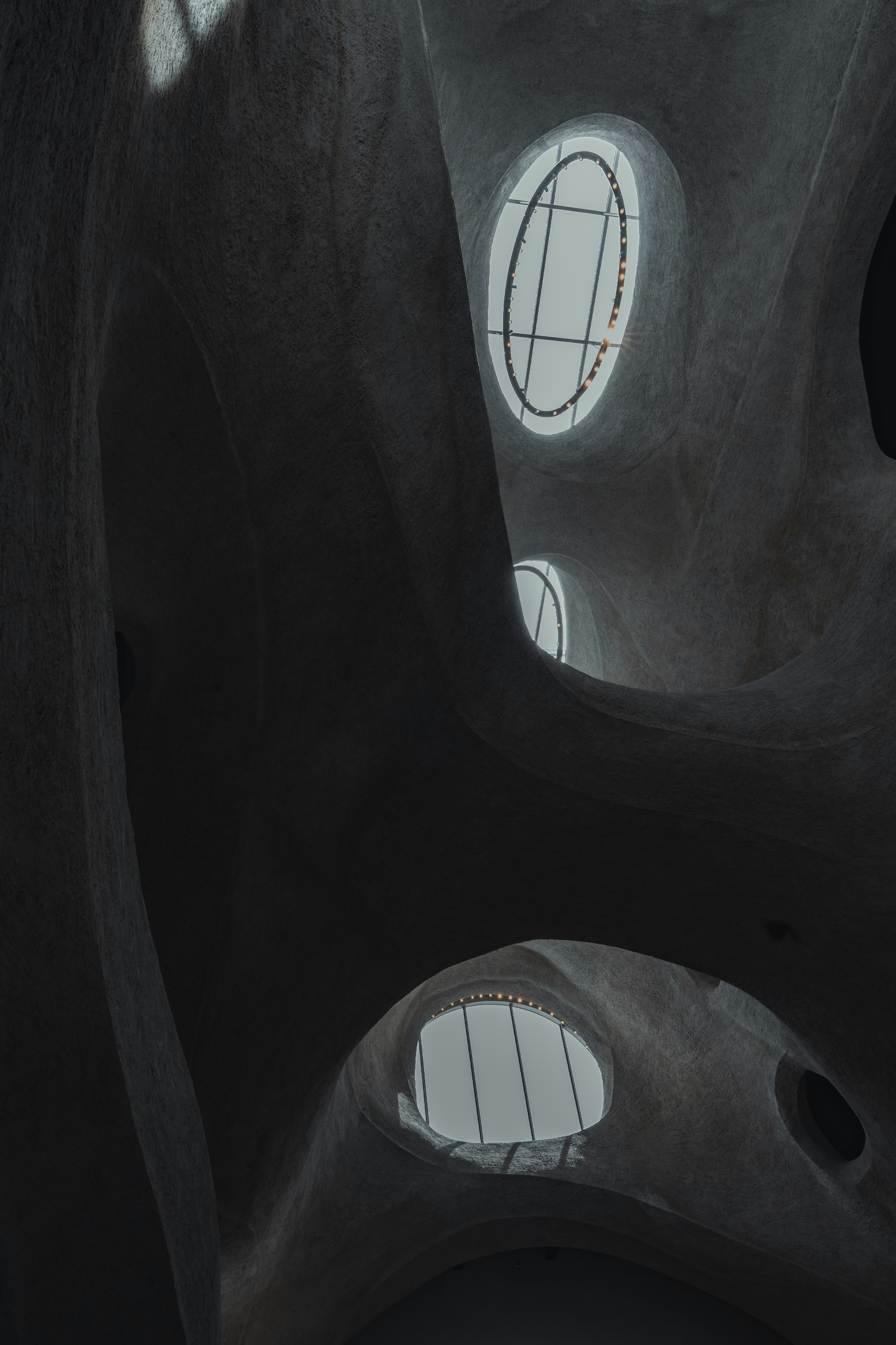 Oculus Cathedral: Circular skylights carving shadows through sculpted concrete