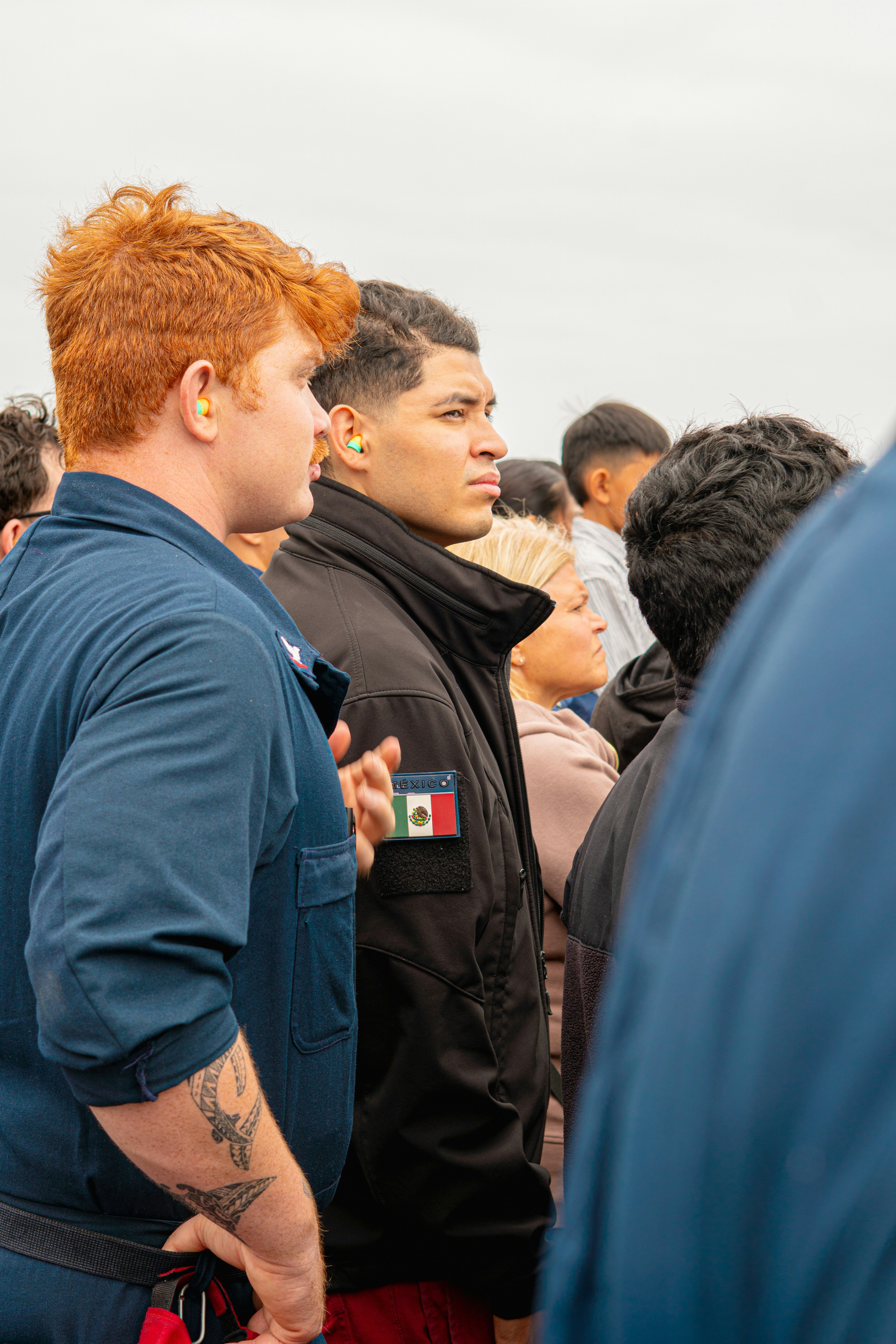 Red-Headed Focus: Youth Crowd in Profile with Mexican Patch