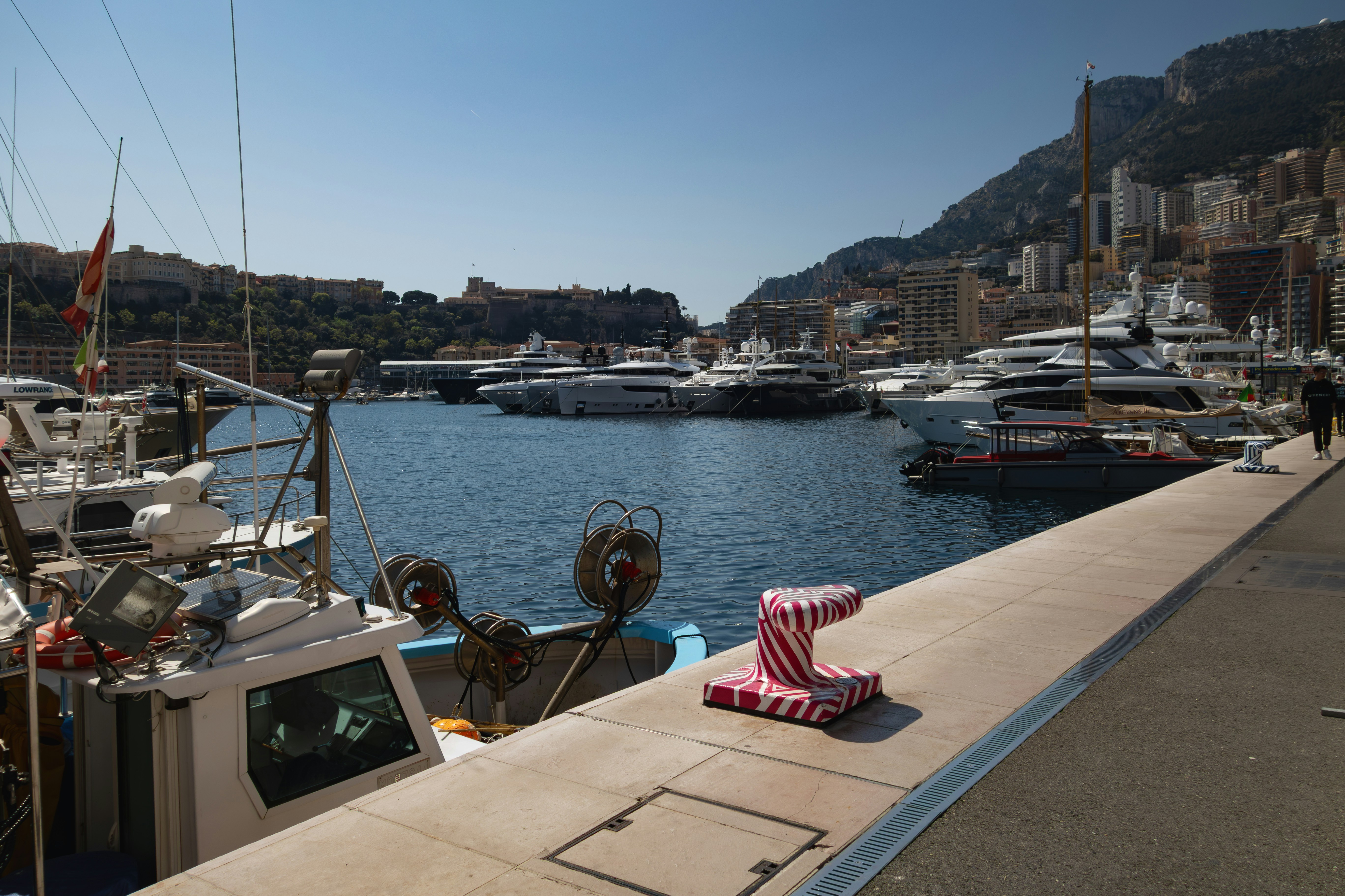 Marina at Docks: Yachts, Concrete Pier and Red-Striped Cushions under a Blue Sky