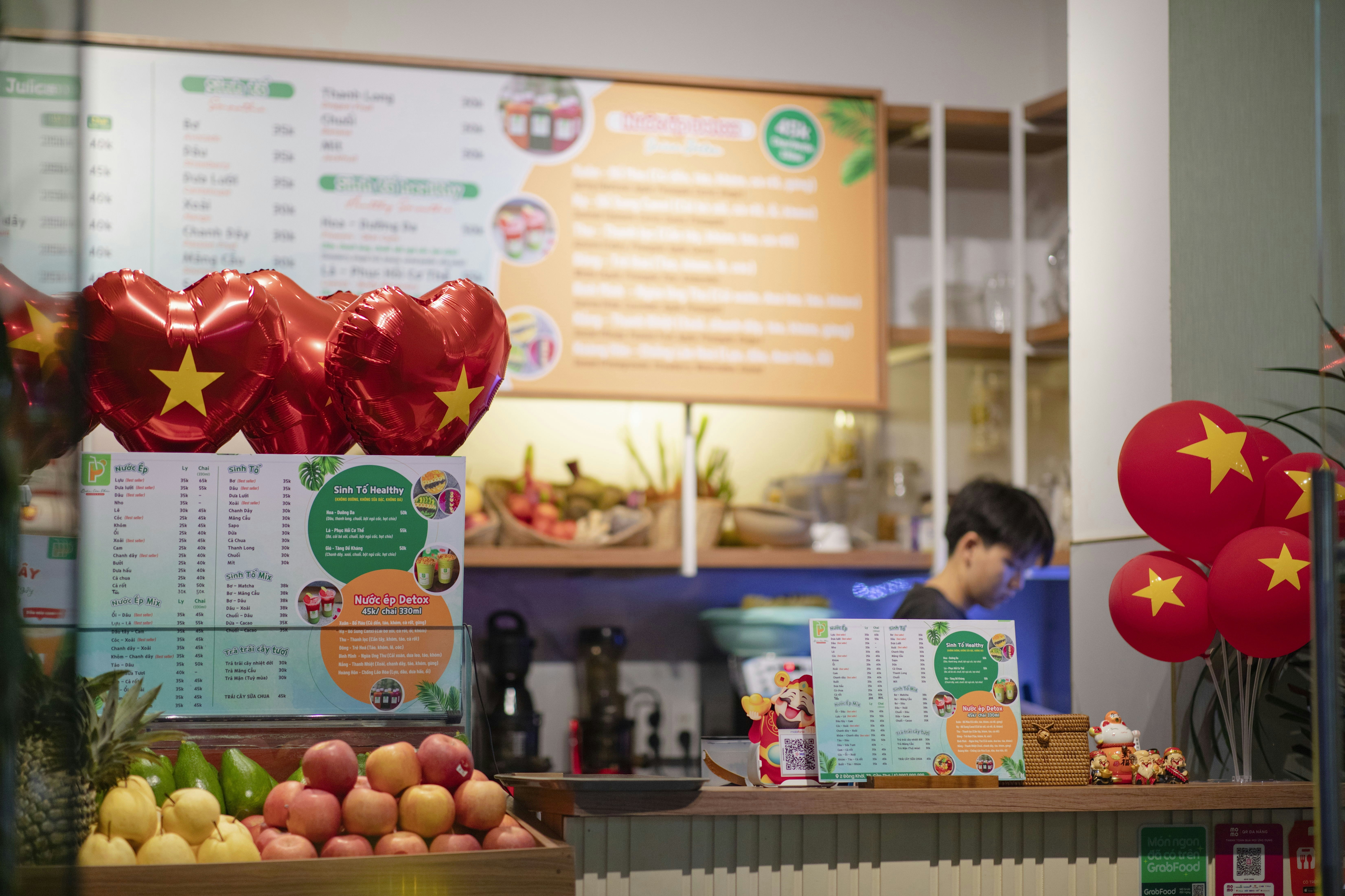 Heart-Shaped Balloons Framing a Bustling Vietnamese Café Counter