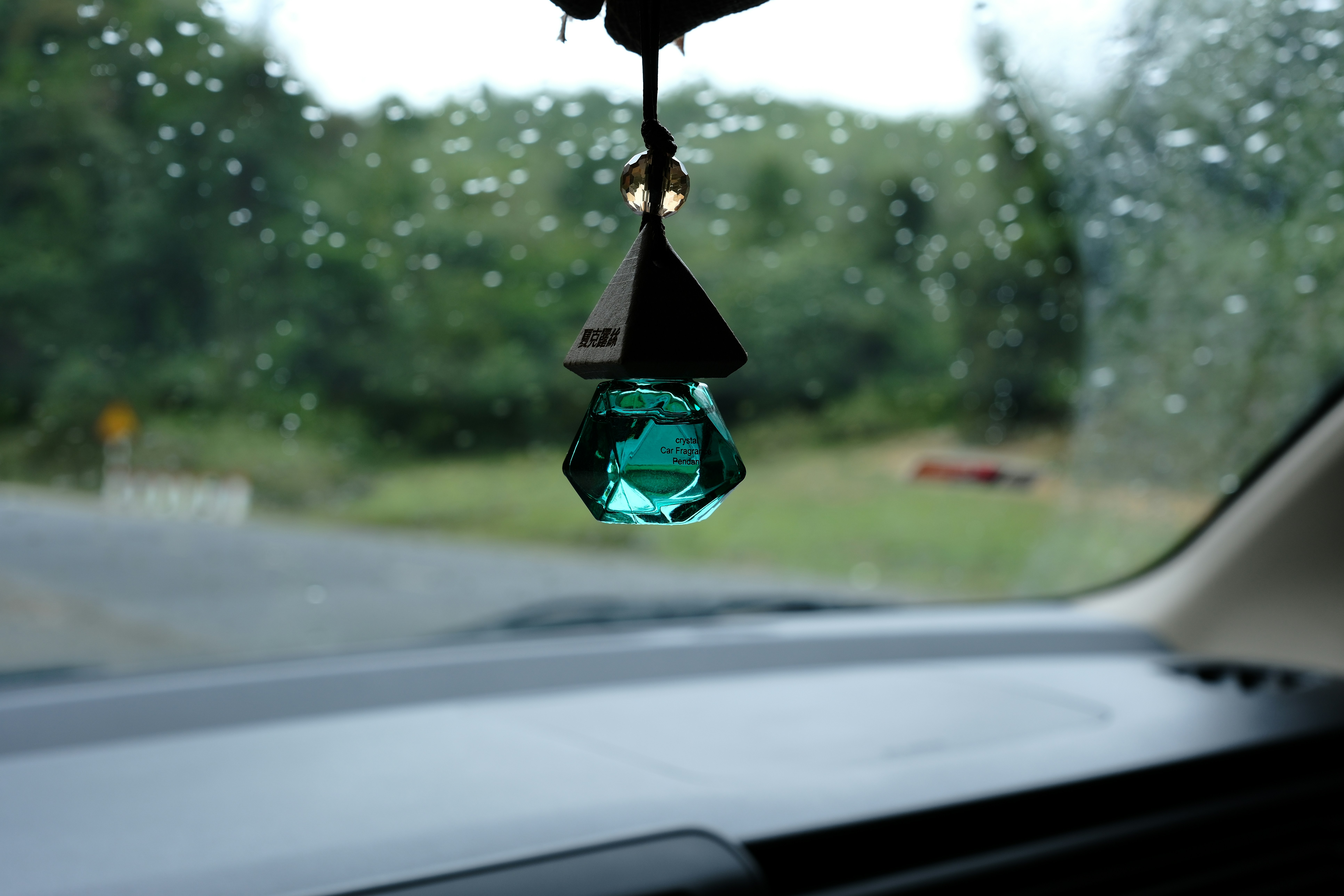 Teal Prism on a Rain-Dusted Windshield