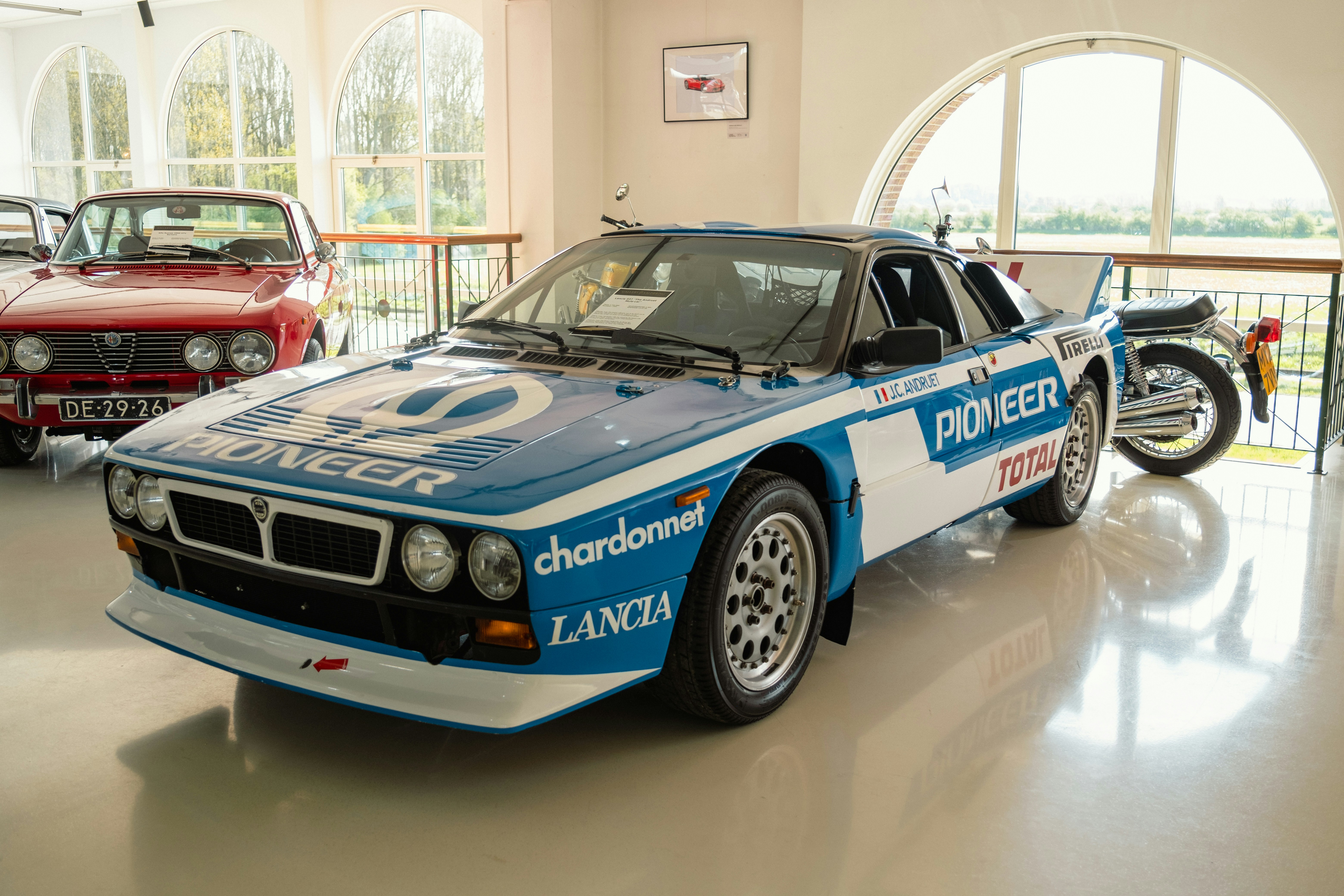 A lancia rally car sits inside a showroom. photo – Free Car Image on ...