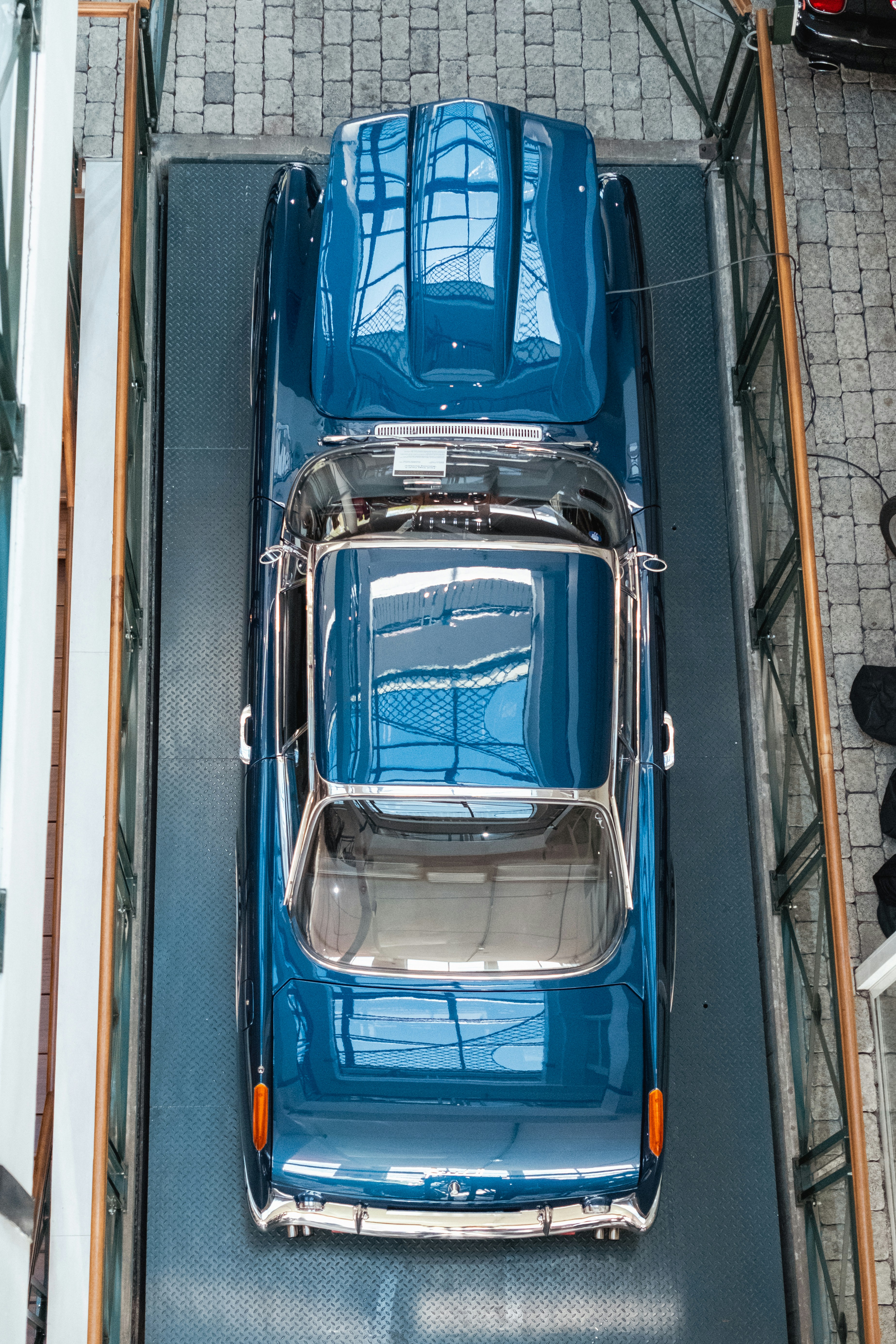 Blue Chrome in a Glass Elevator: A Top-Down Portrait of a Vintage Car