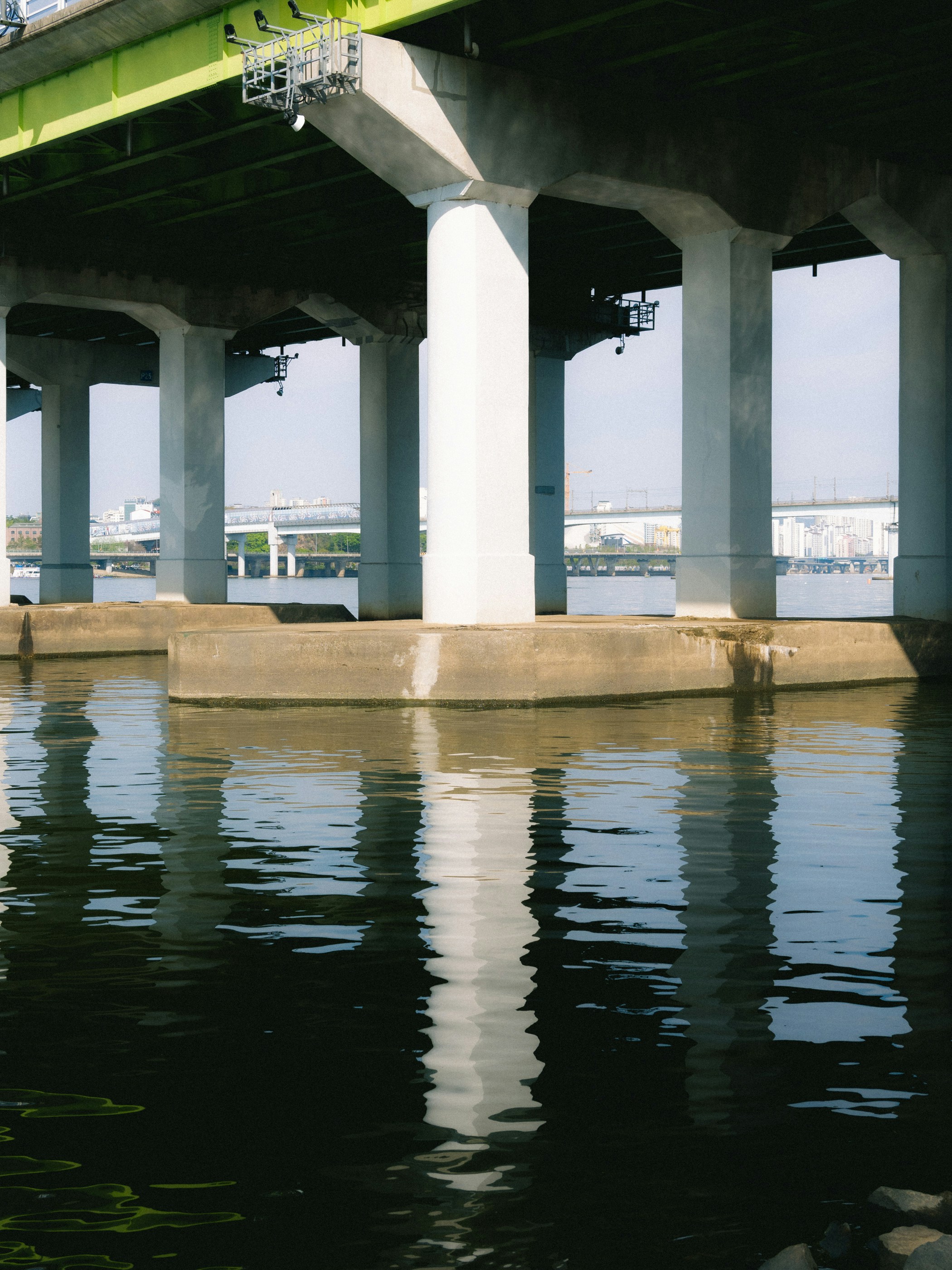 Bridge pillars reflect in the rippling water below. photo – Free ...