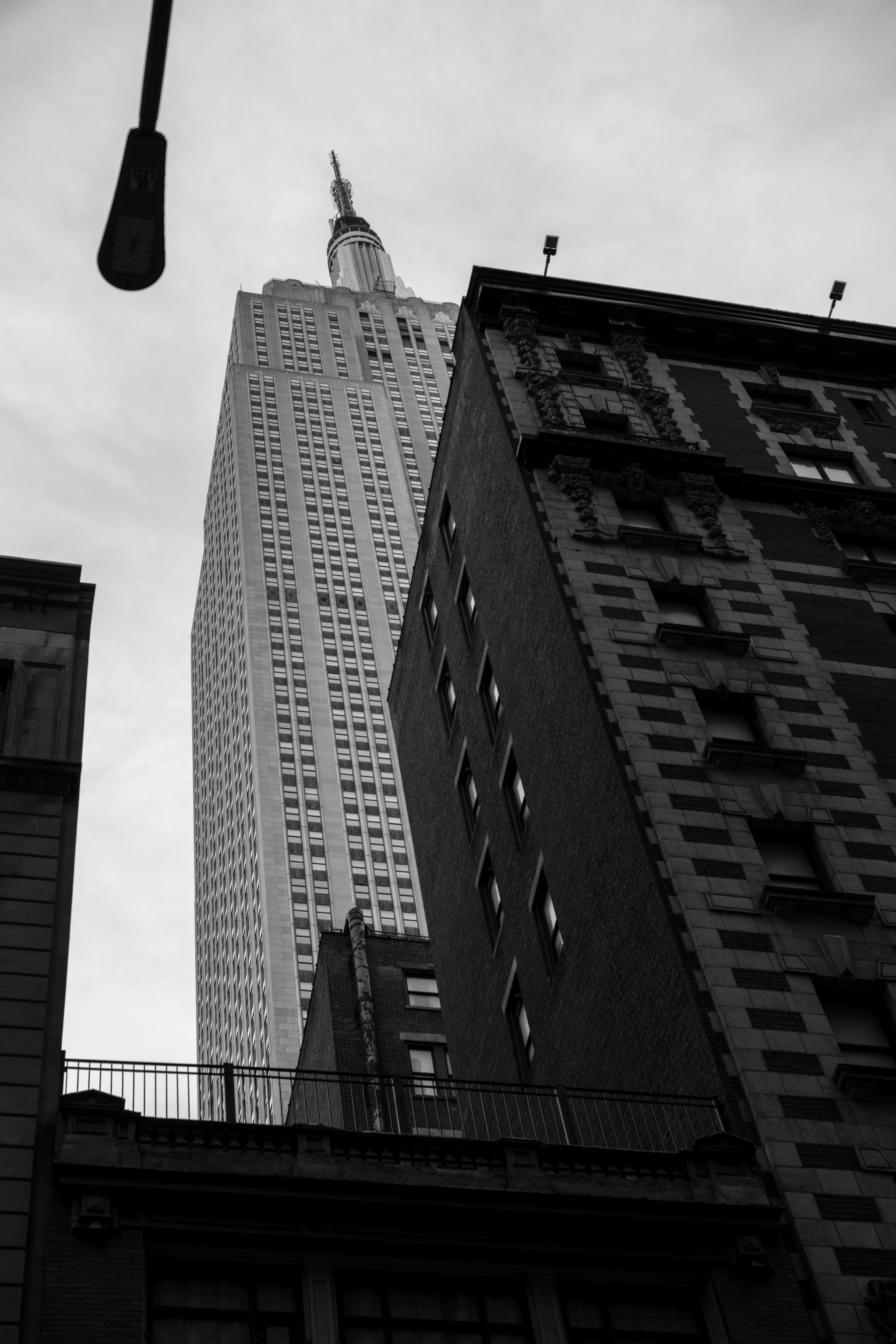 The empire state building towers above other buildings. photo – Free ...