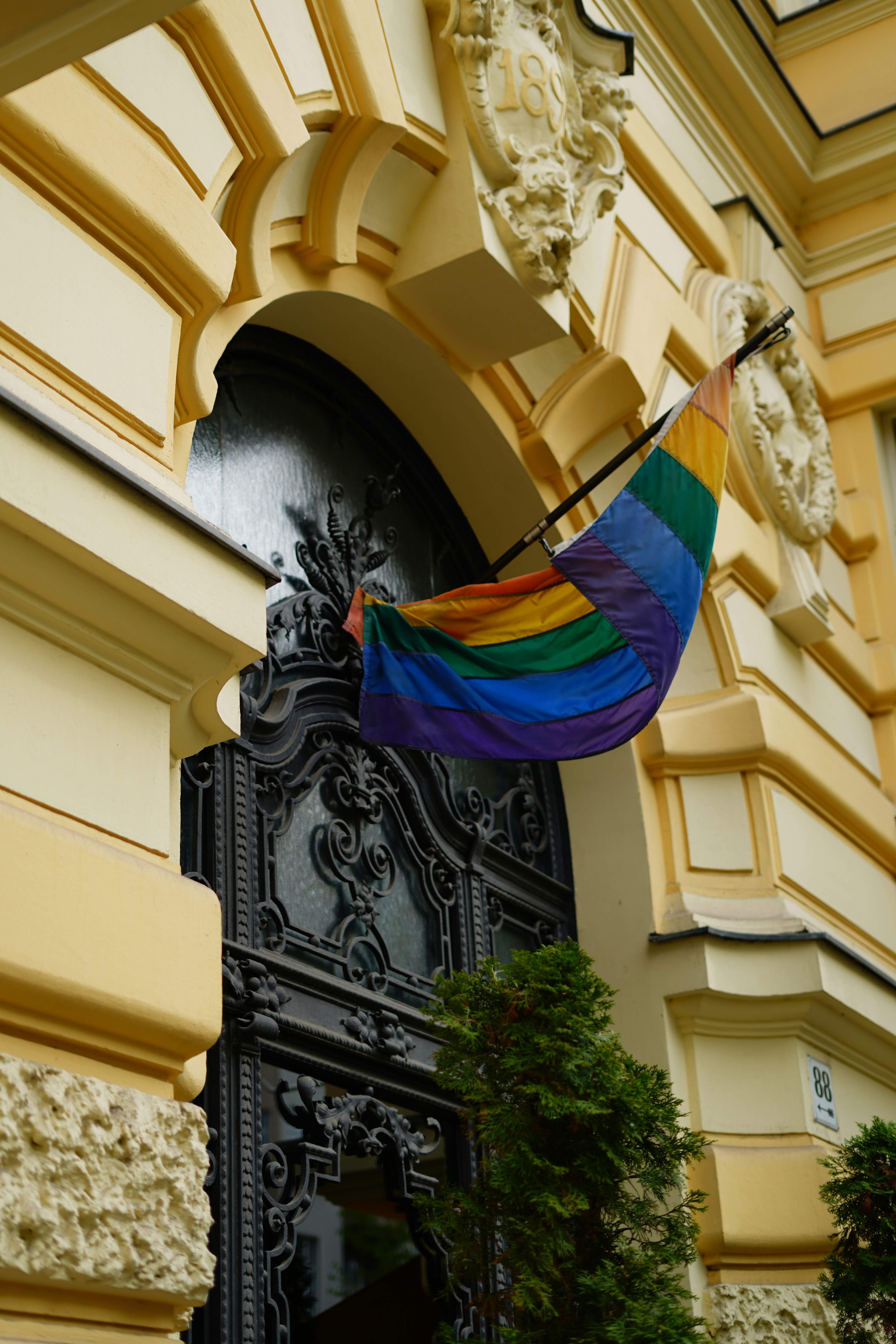 Rainbow Banner Drapes Across a Yellow Neoclassical Doorway