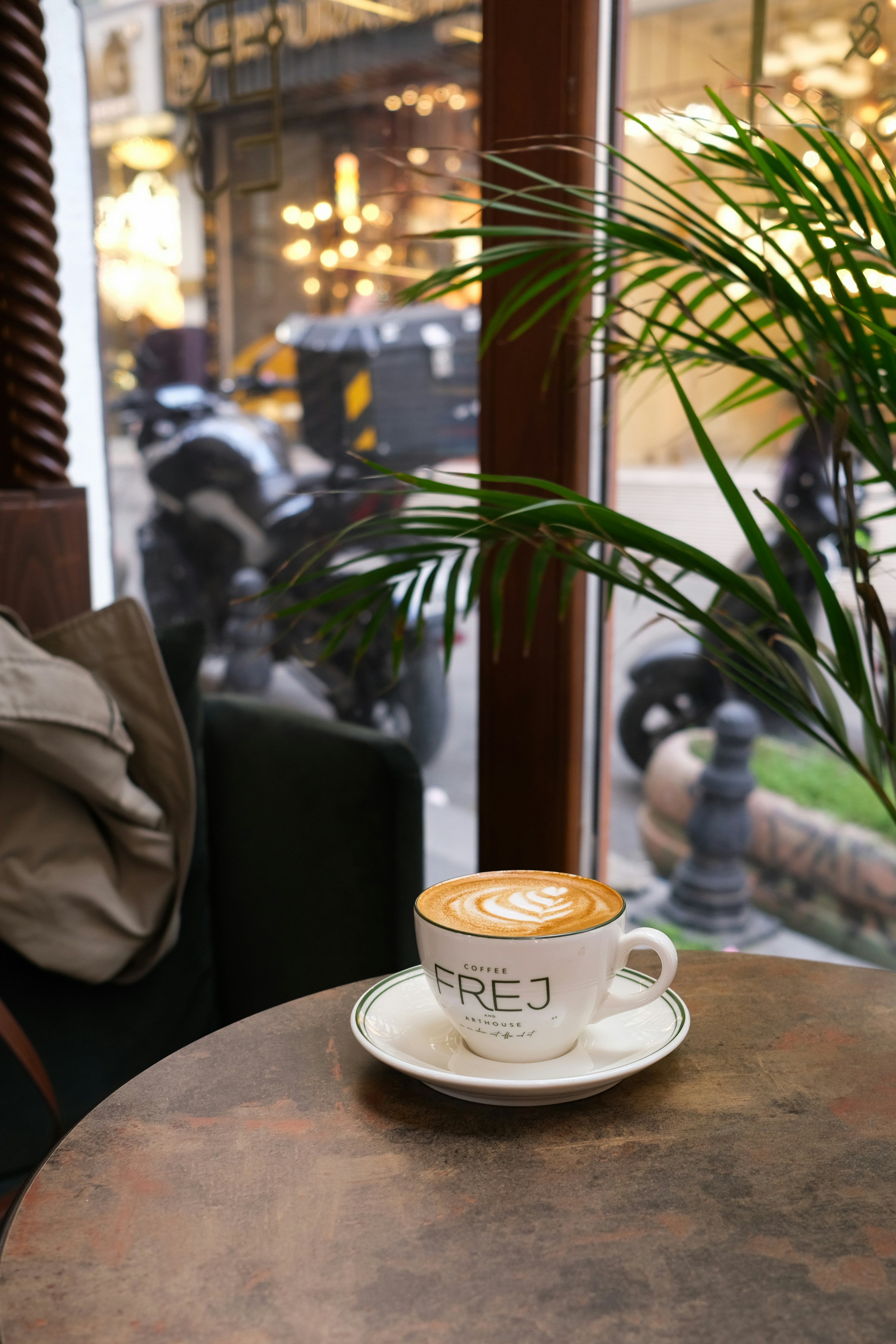 Un café au lait repose sur une table à côté d’une fenêtre. photo ...