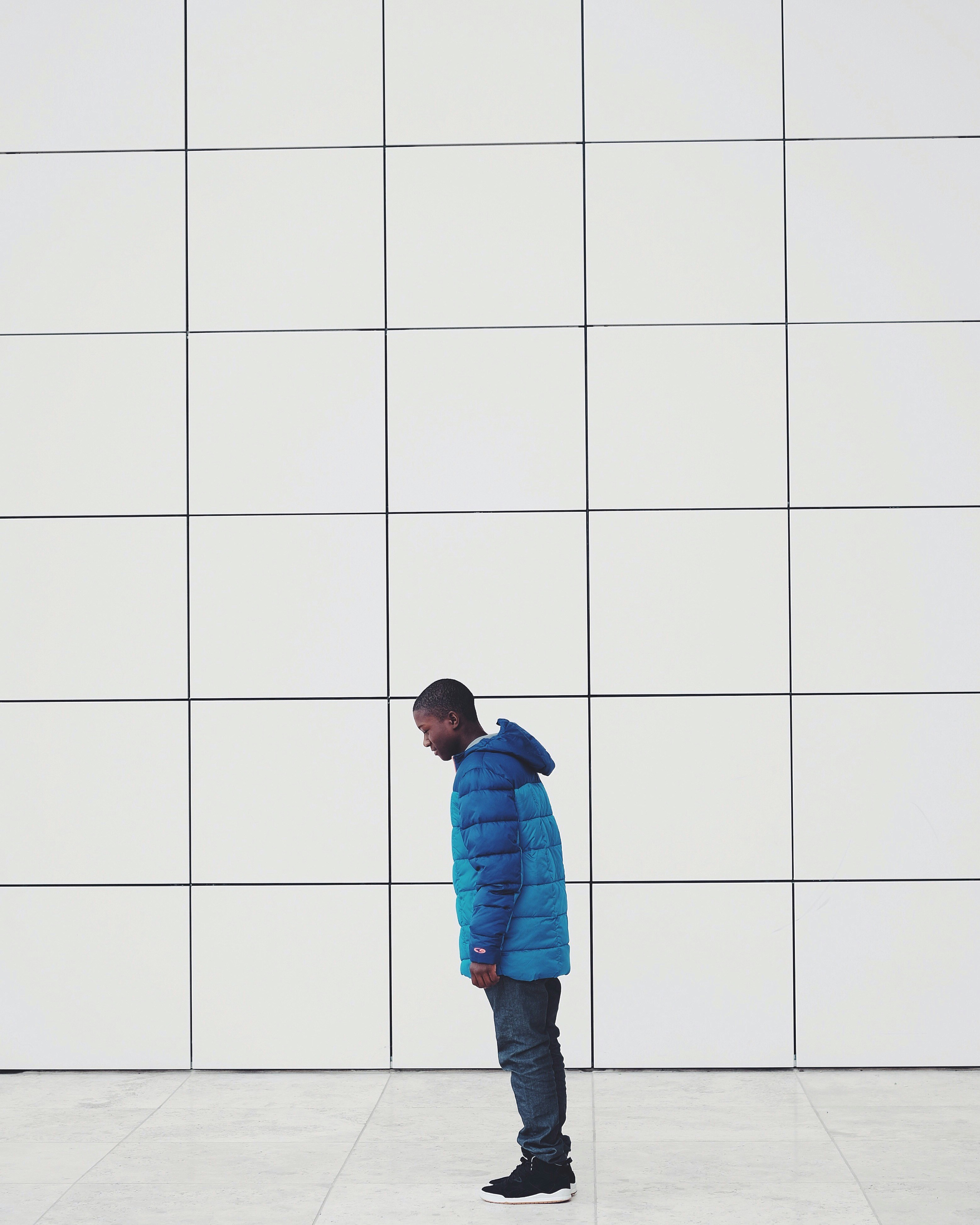 Man stands in front of white, grid wall. photo – Free Portrait Image on ...