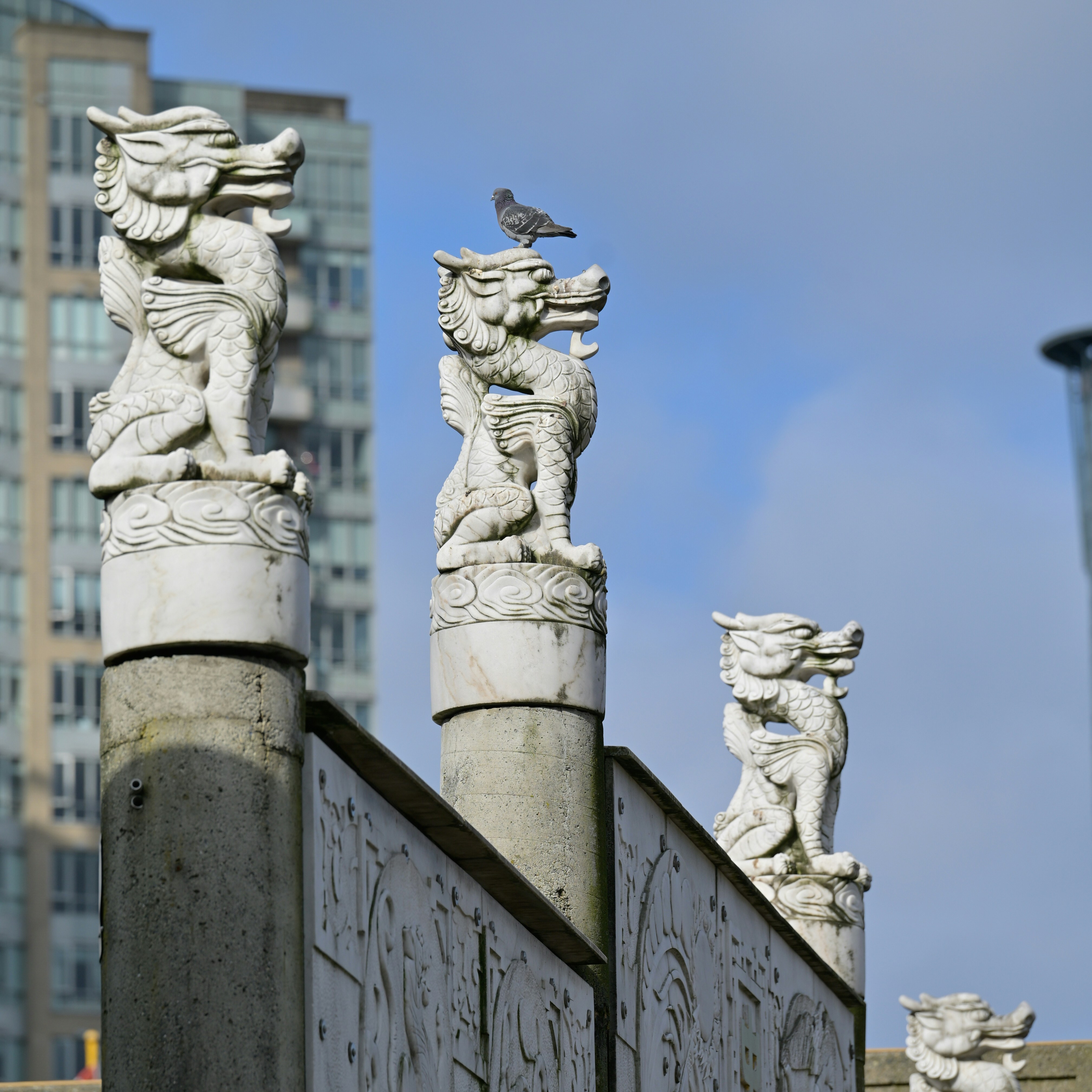 Statues on a sunlit roofline: stone dragons guard the skyline