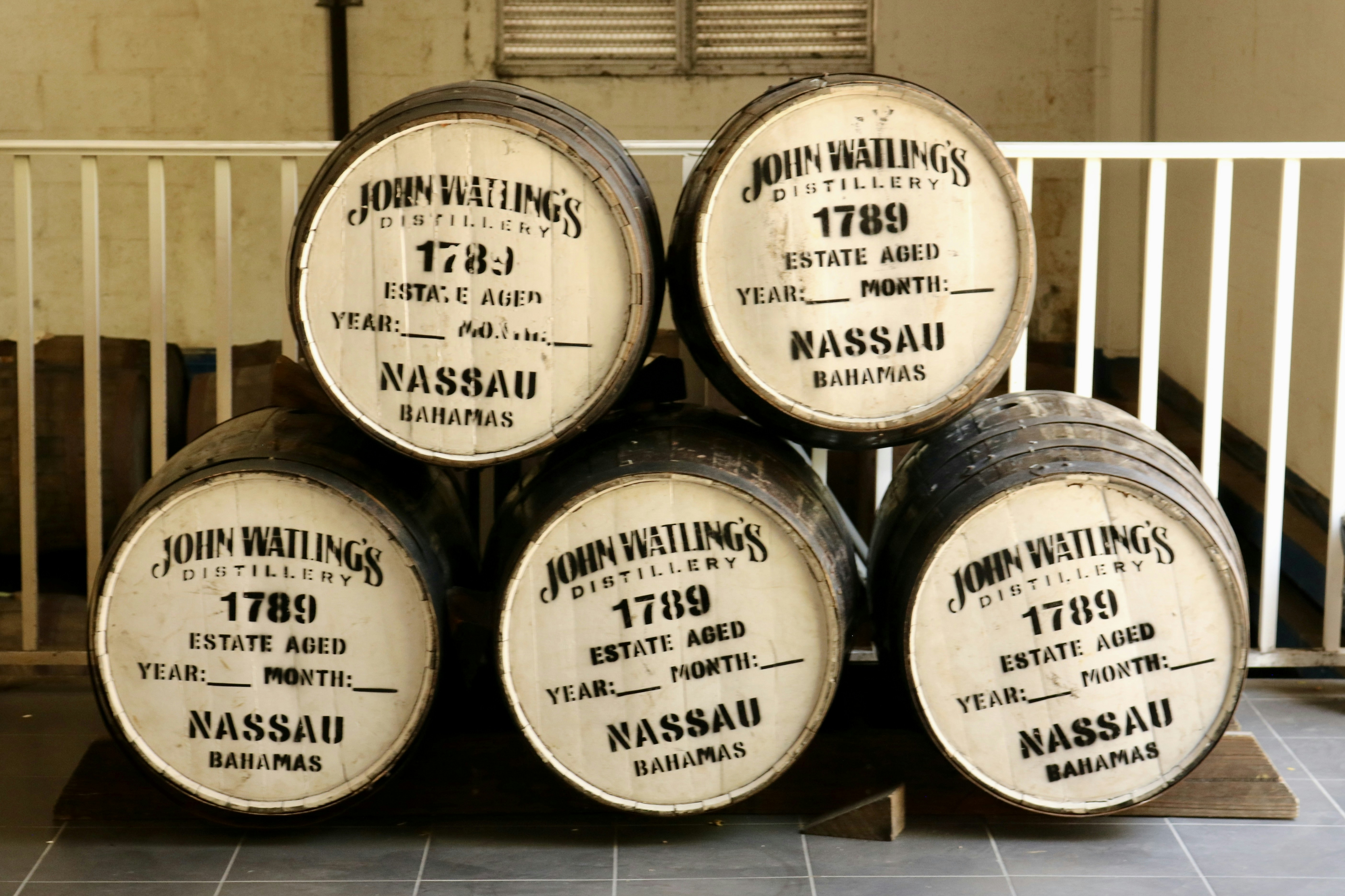 Rum barrels are stacked in a distillery.