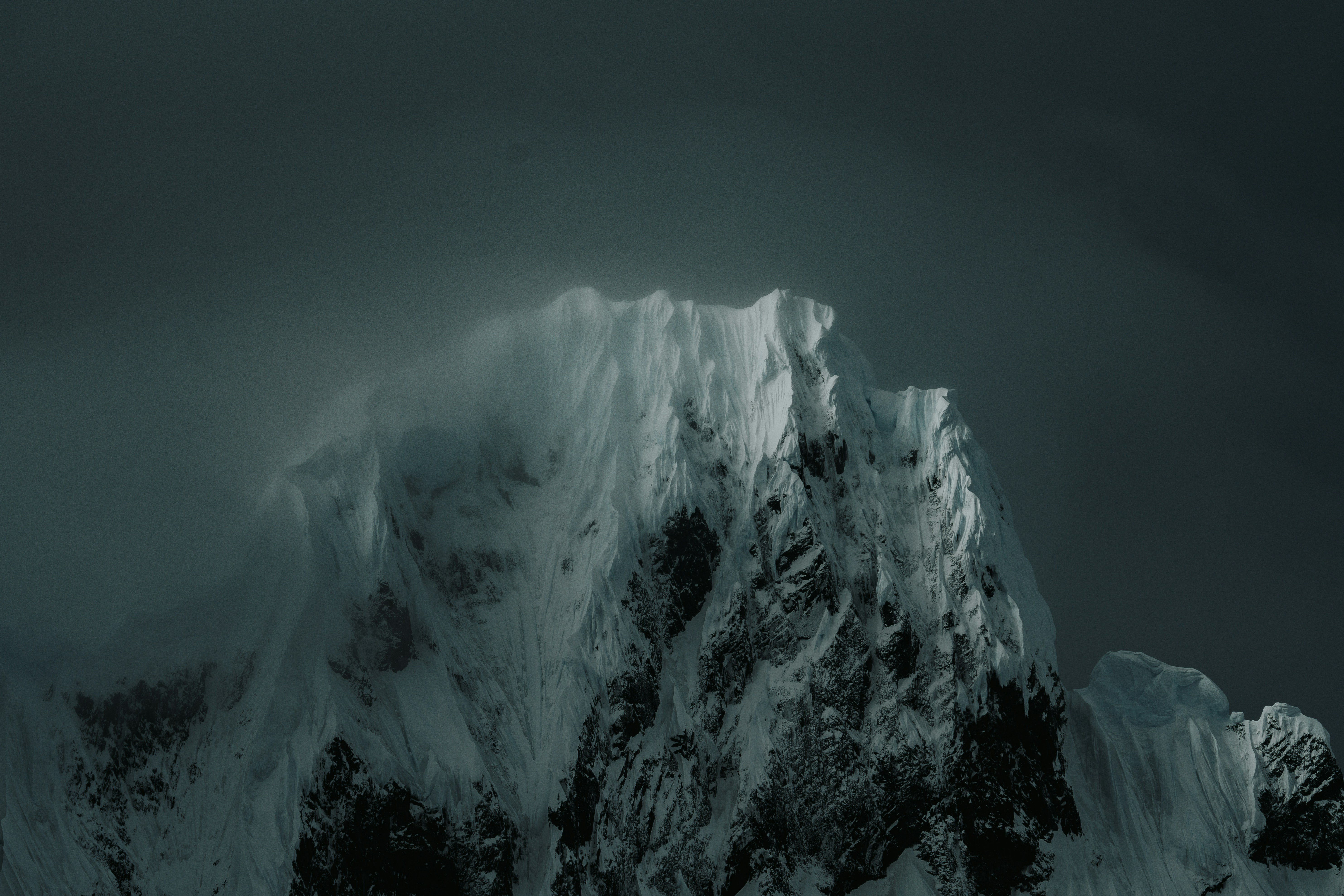 Snowy mountain peaks rise into the dark sky. photo – Free Travel Image ...