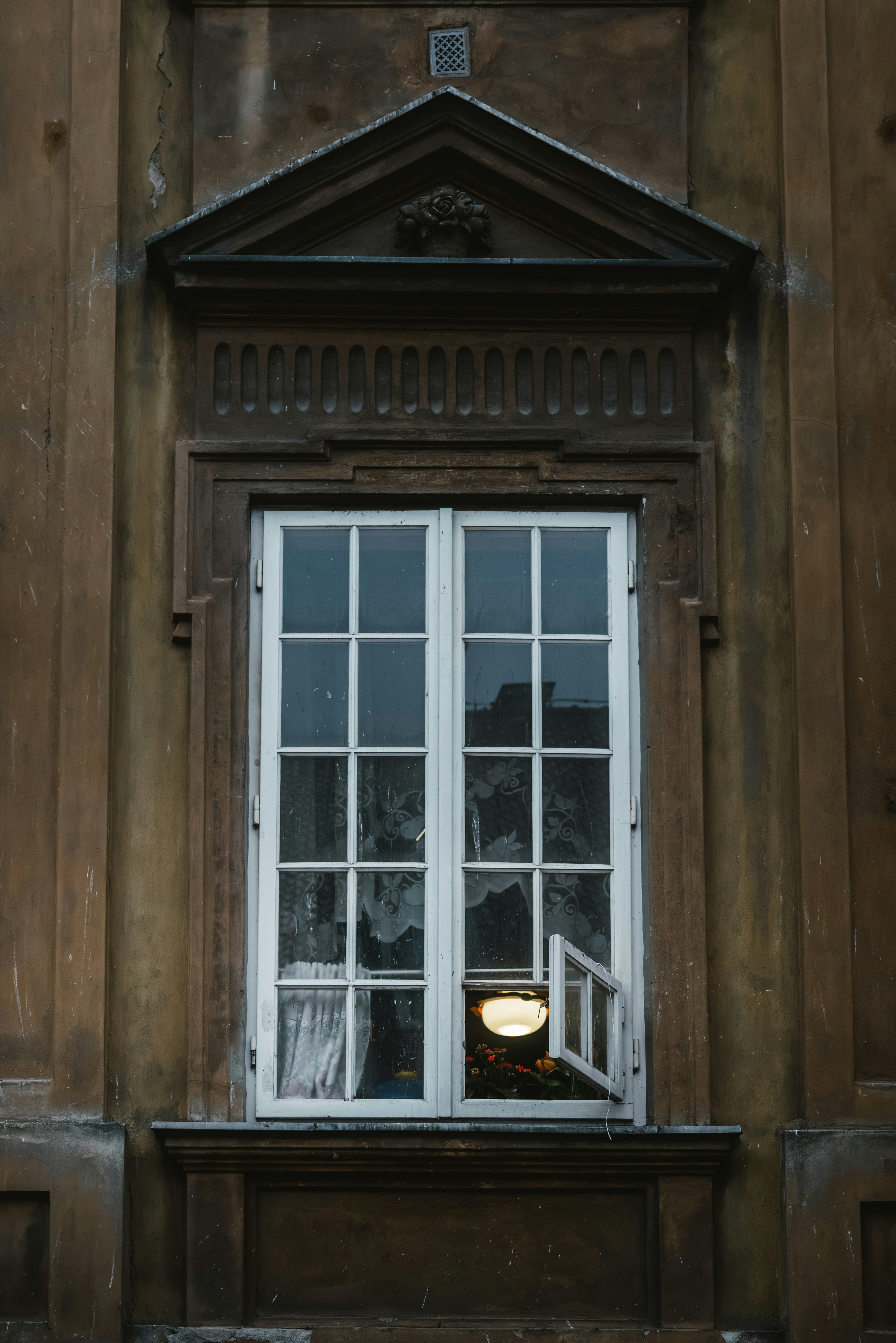 Amber Light Through a Weathered Window: A Quiet Moment in a Historic Facade