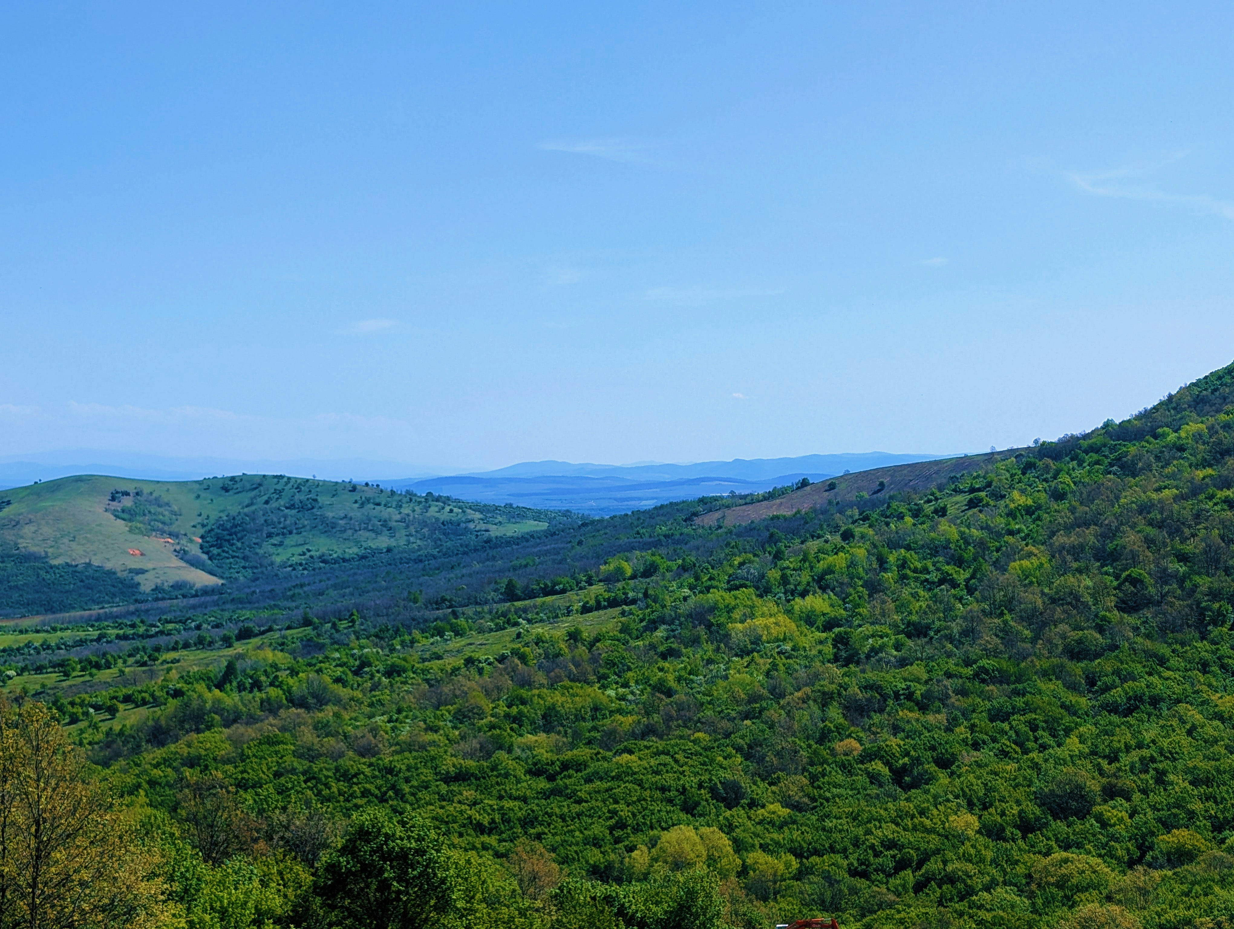 Rolling hills and bright green forests under a blue sky. photo – Free ...