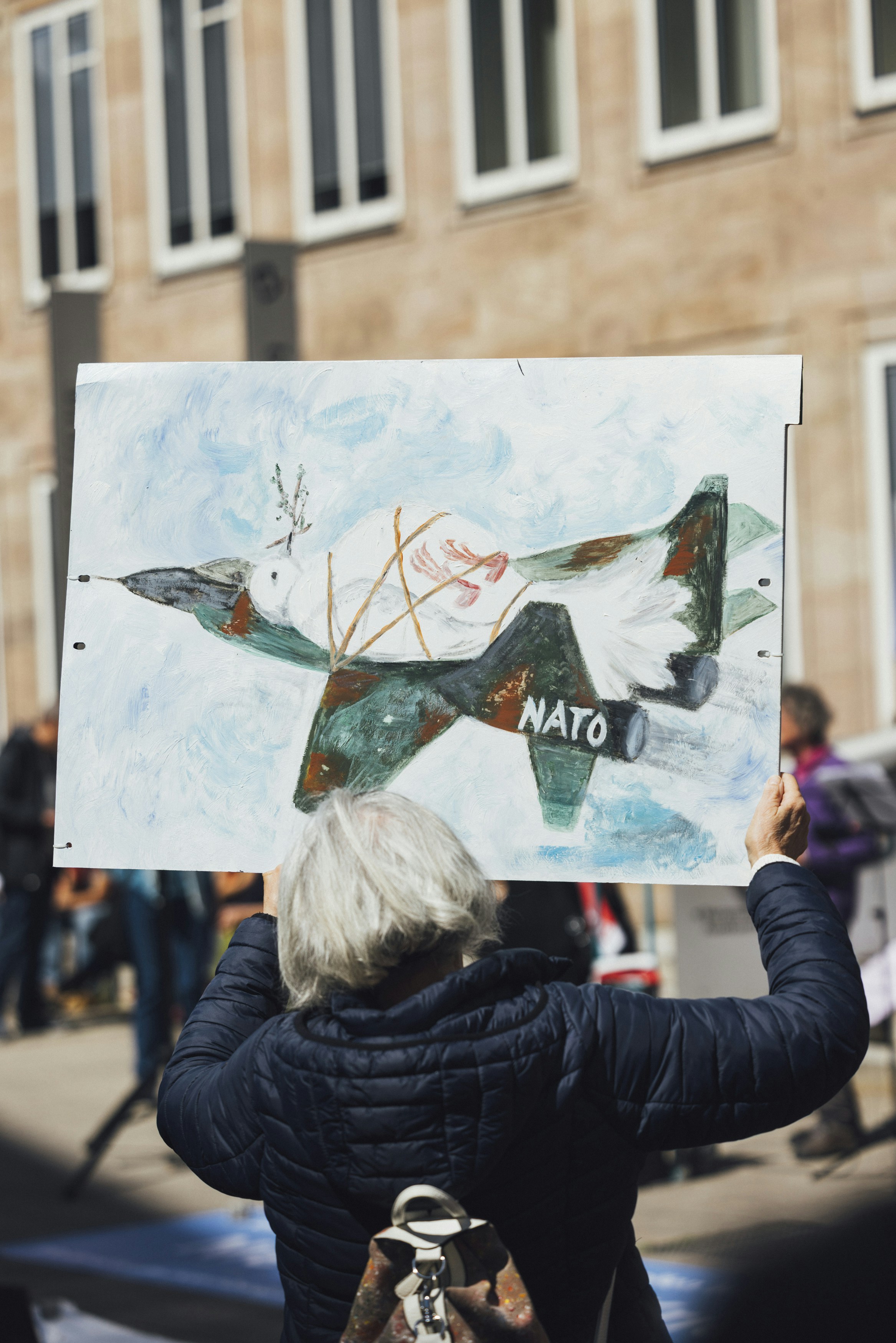 Protester holds a drawing of an airplane labeled nato. photo – Free Usa ...
