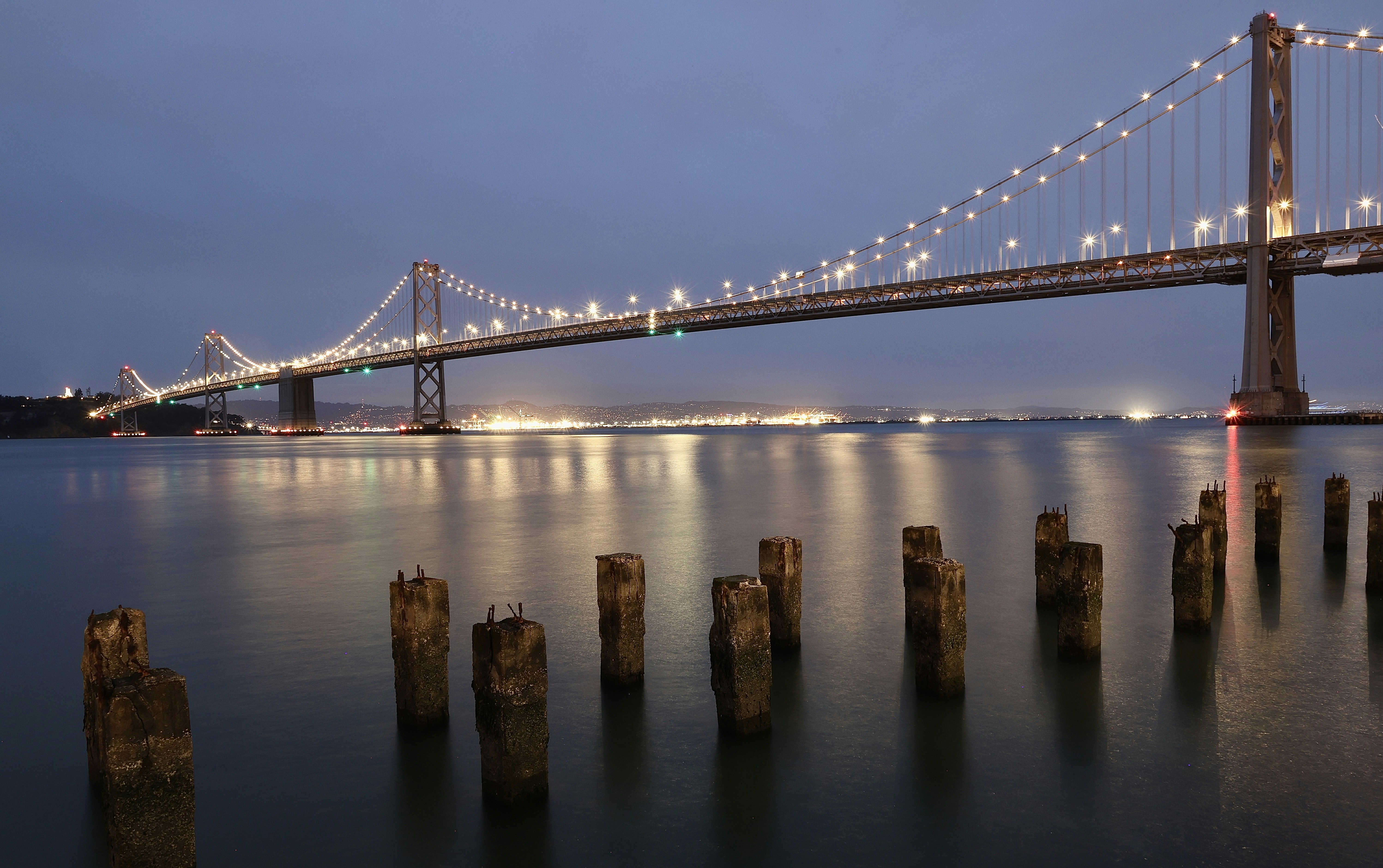 A lit-up bridge over water at twilight. photo – Free San francisco ...