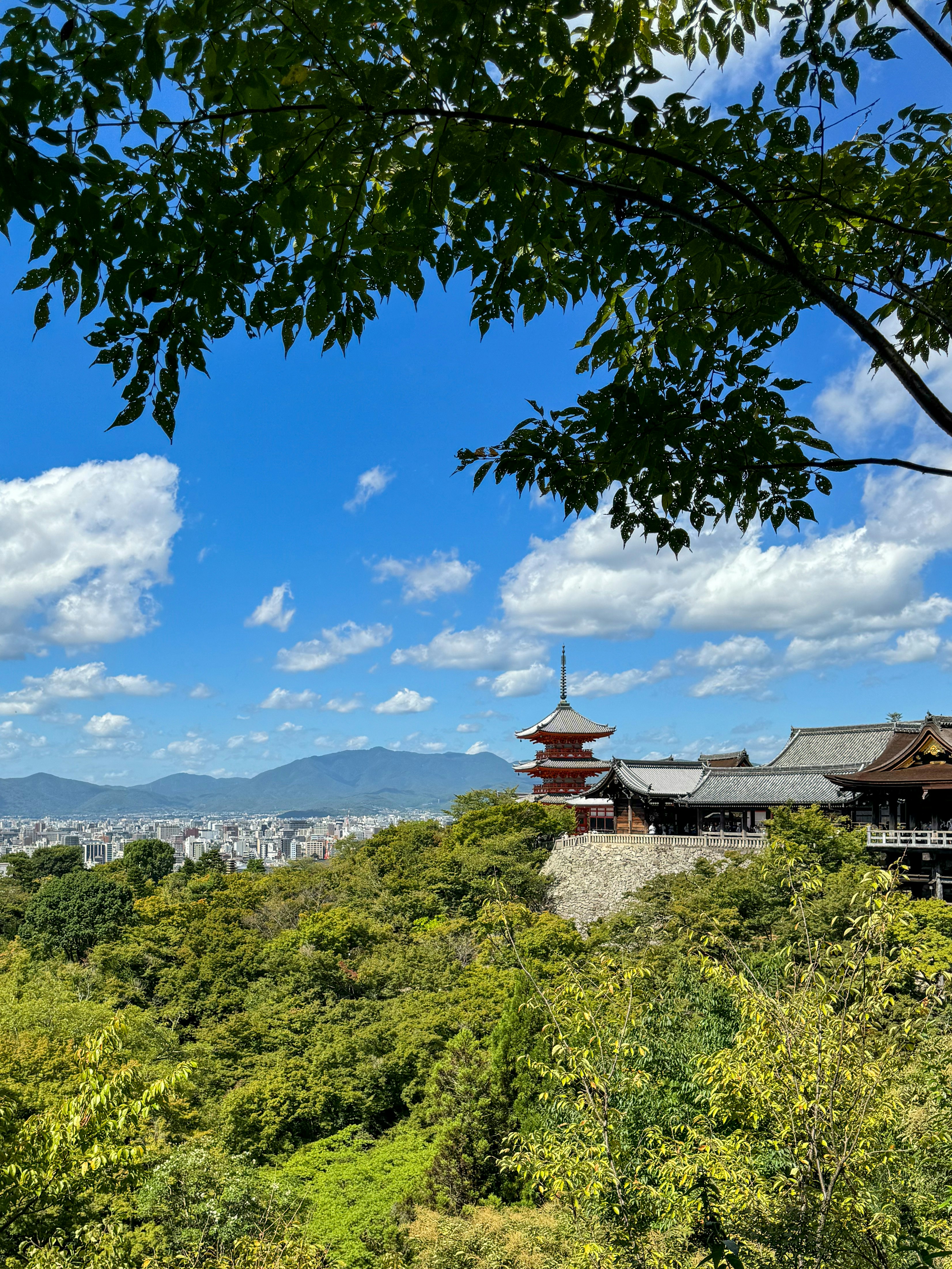 Hilltop Pagoda Above a Verdant Ridge with a Distant City Skyline
