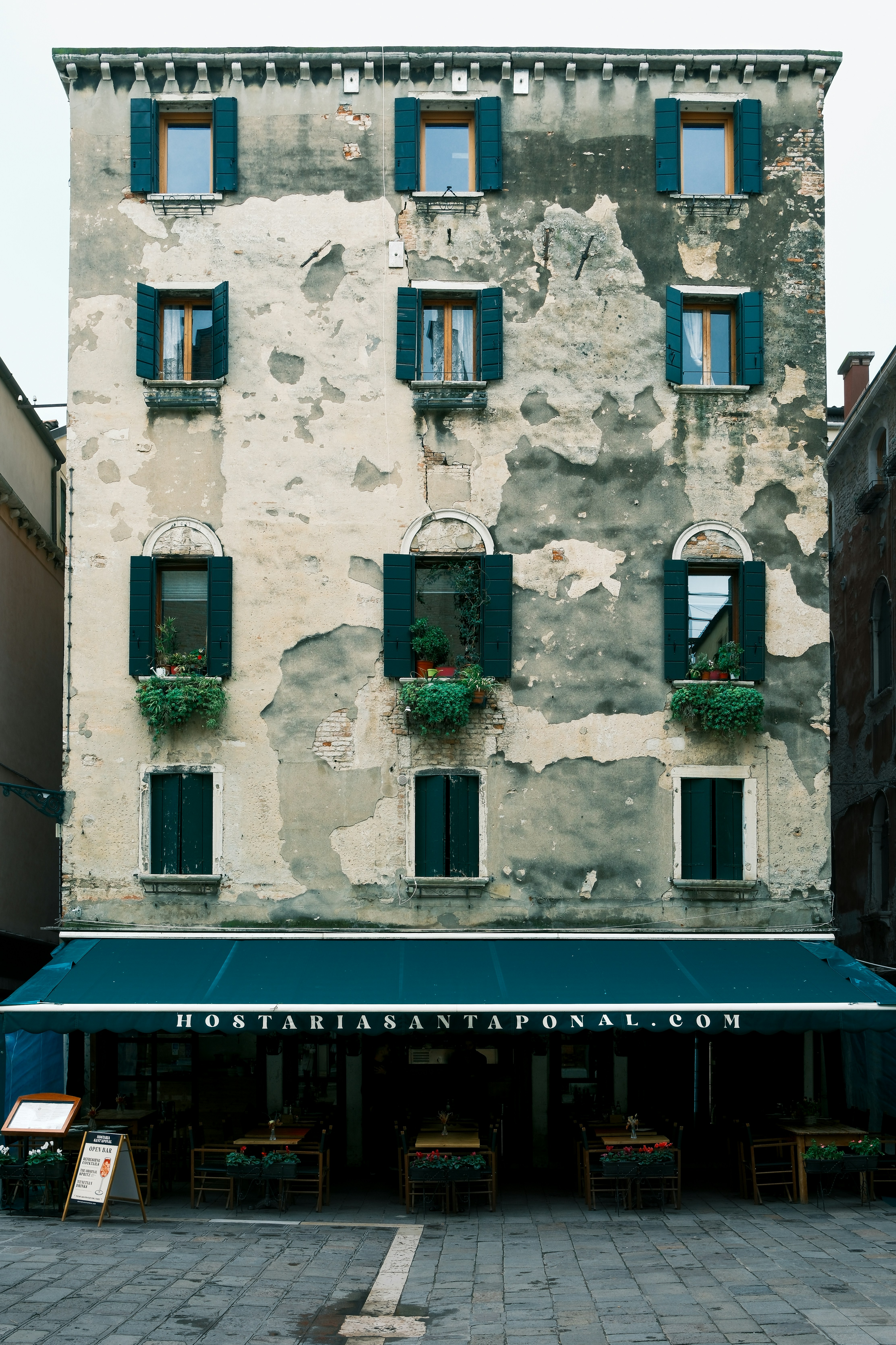 Timeworn Stucco, Teal Shutters, and a Streetfront Café
