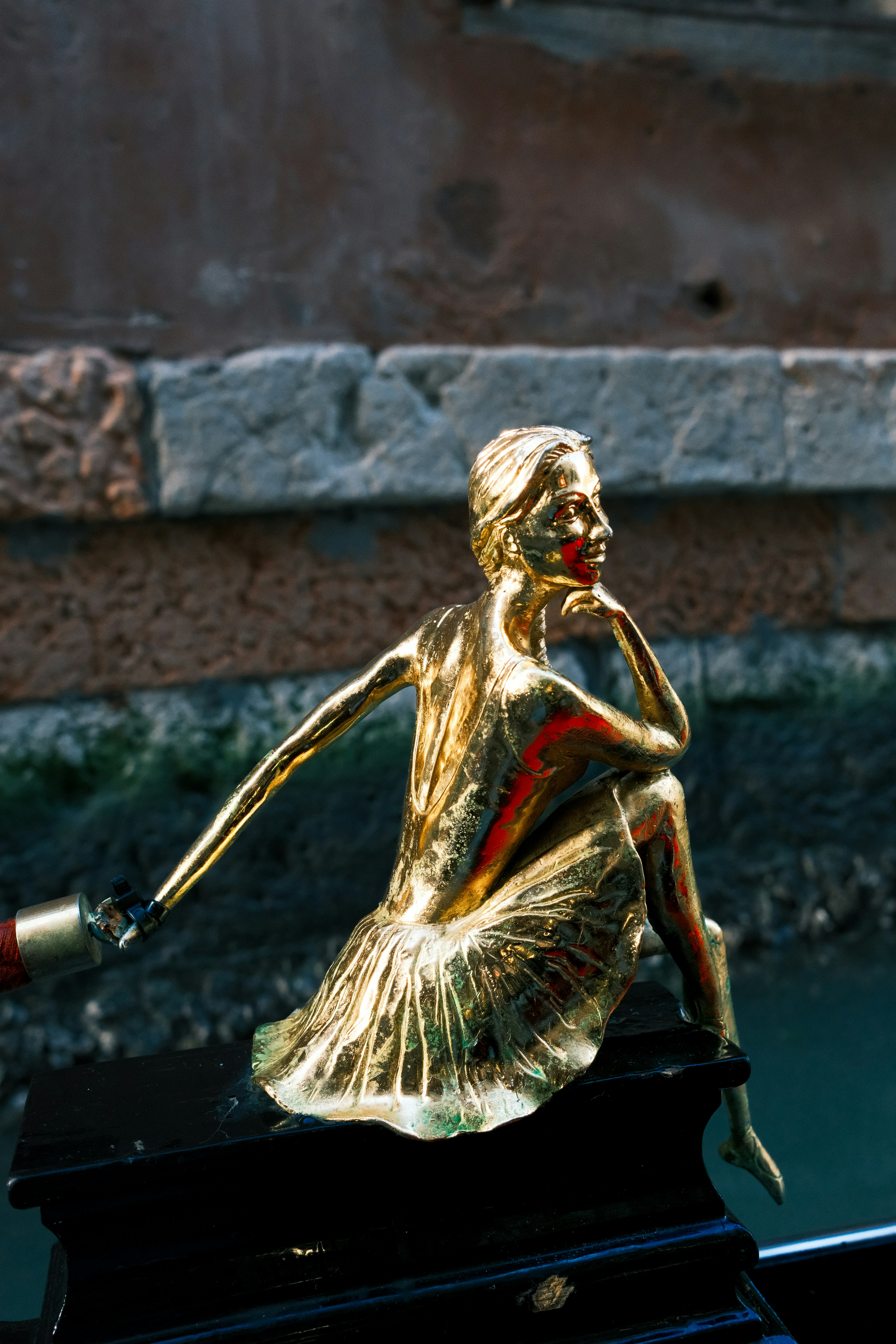 Gilded Contemplation by a Weathered Canal Wall