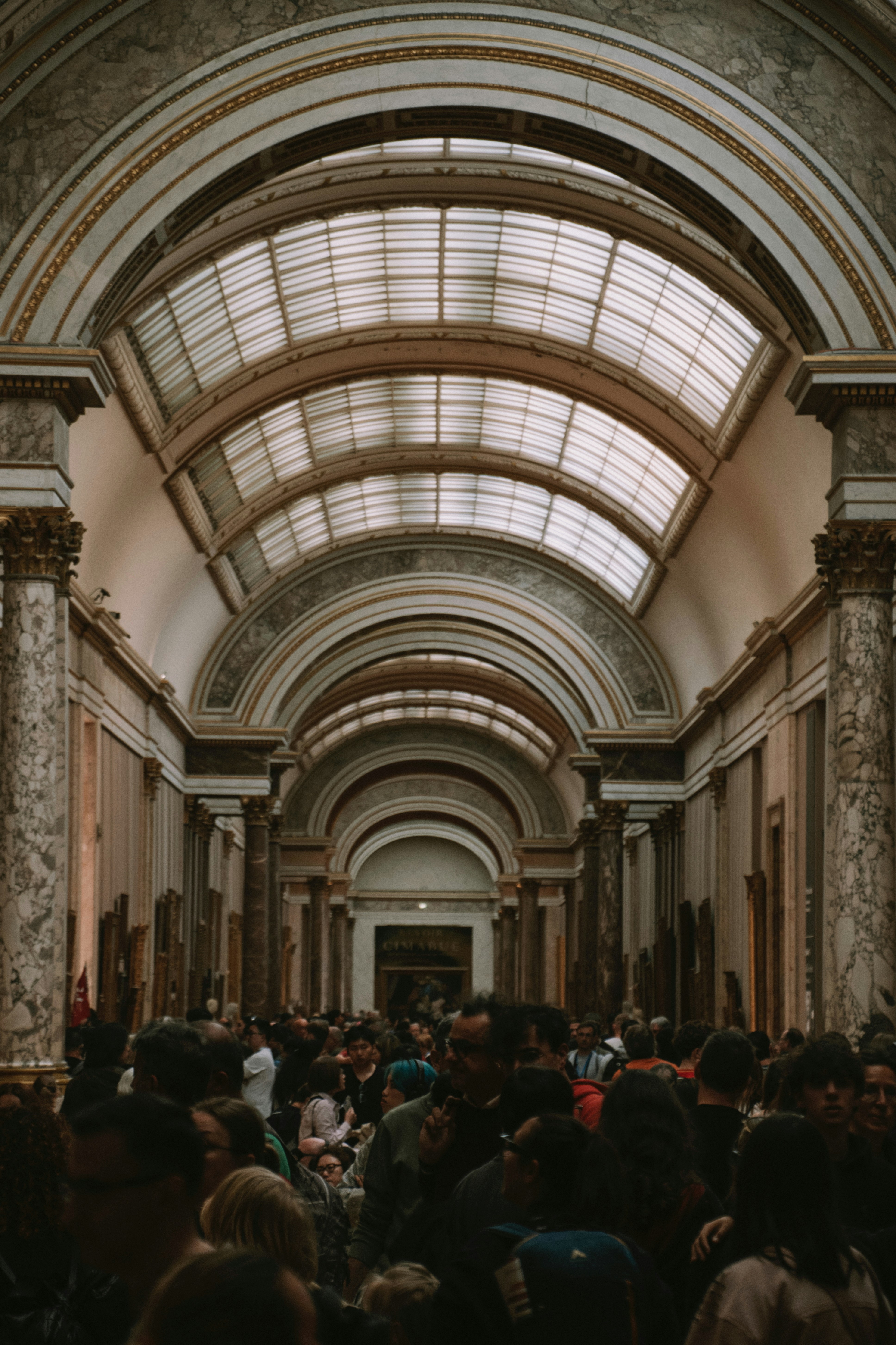 People explore an ornate, high-ceilinged art gallery. photo – Free Woman Image on Unsplash