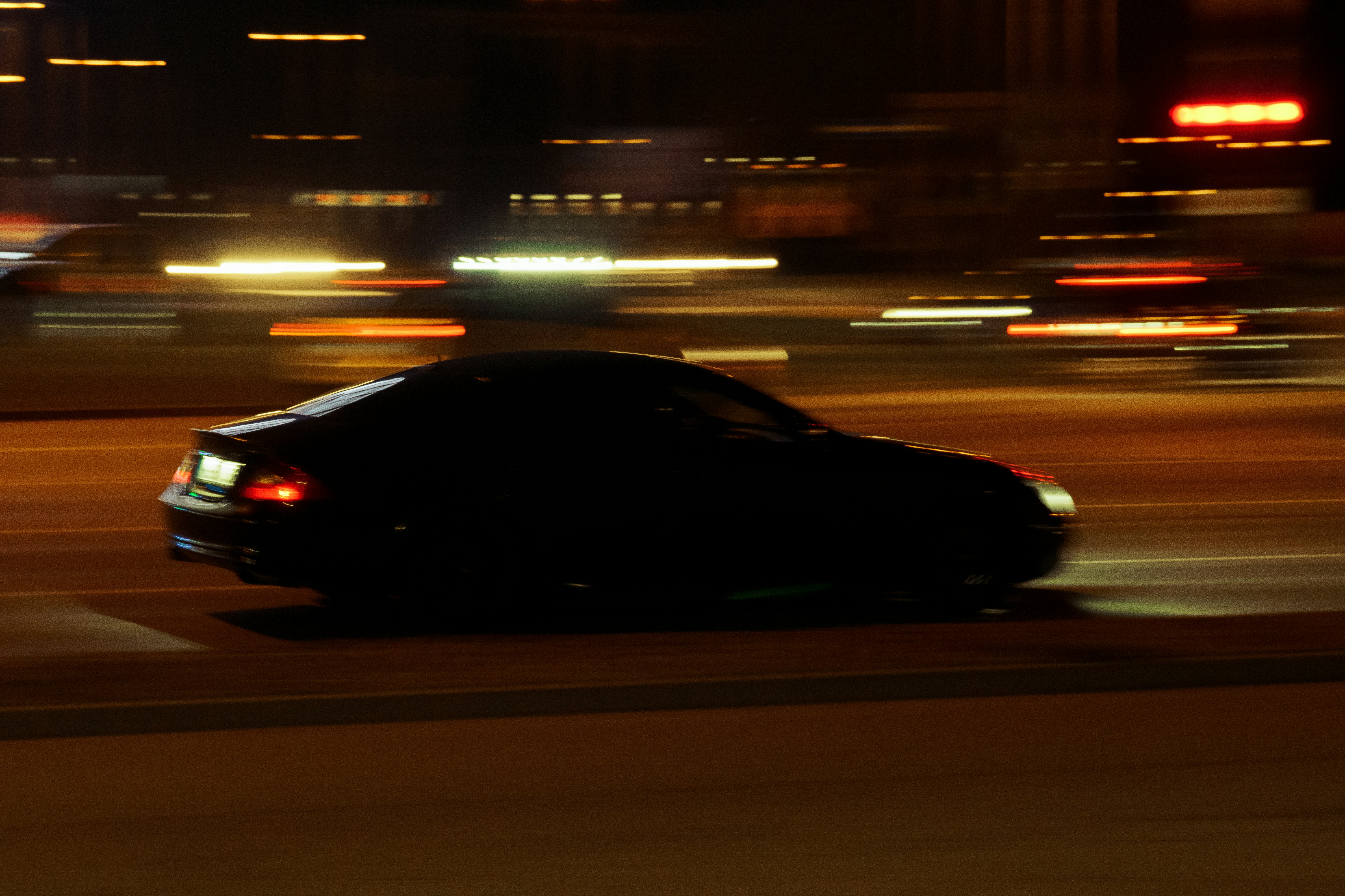 Midnight Blur: Neon-Lit Sedan in Motion