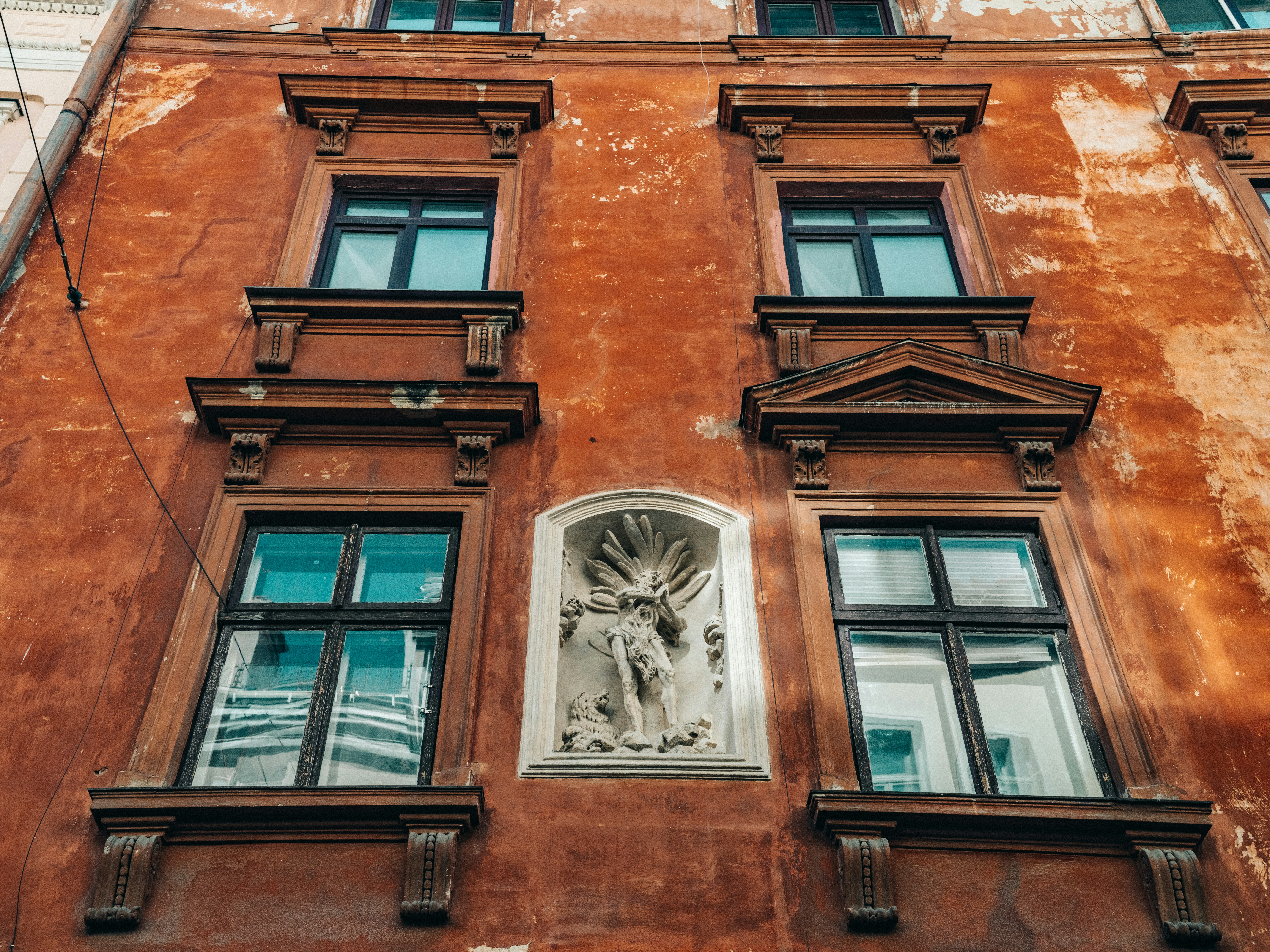 Rust and Relief: A Weathered Façade with Central Medallion