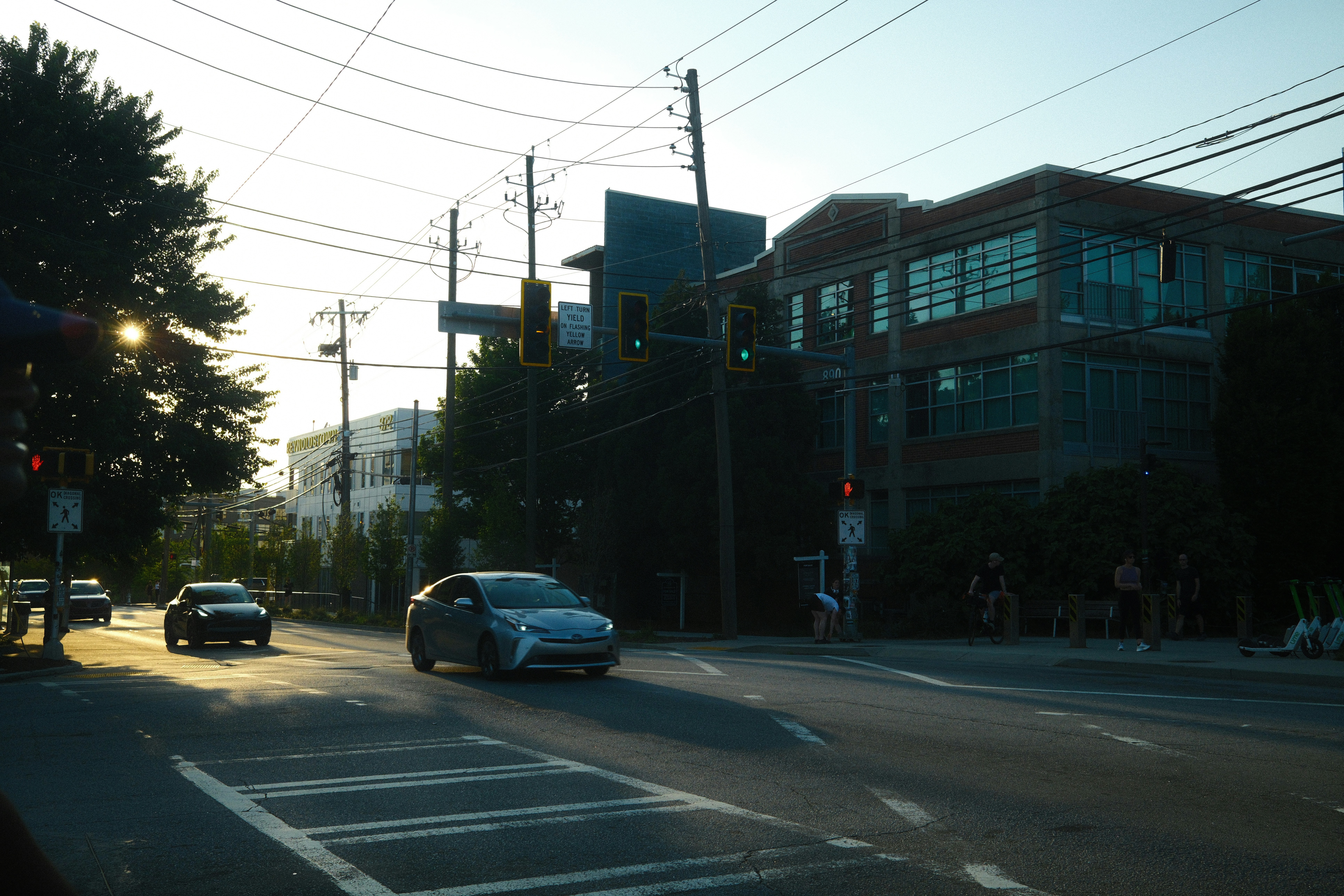 Dusk at the Crosswalk: A Silver Sedan and the City's Quiet Pulse