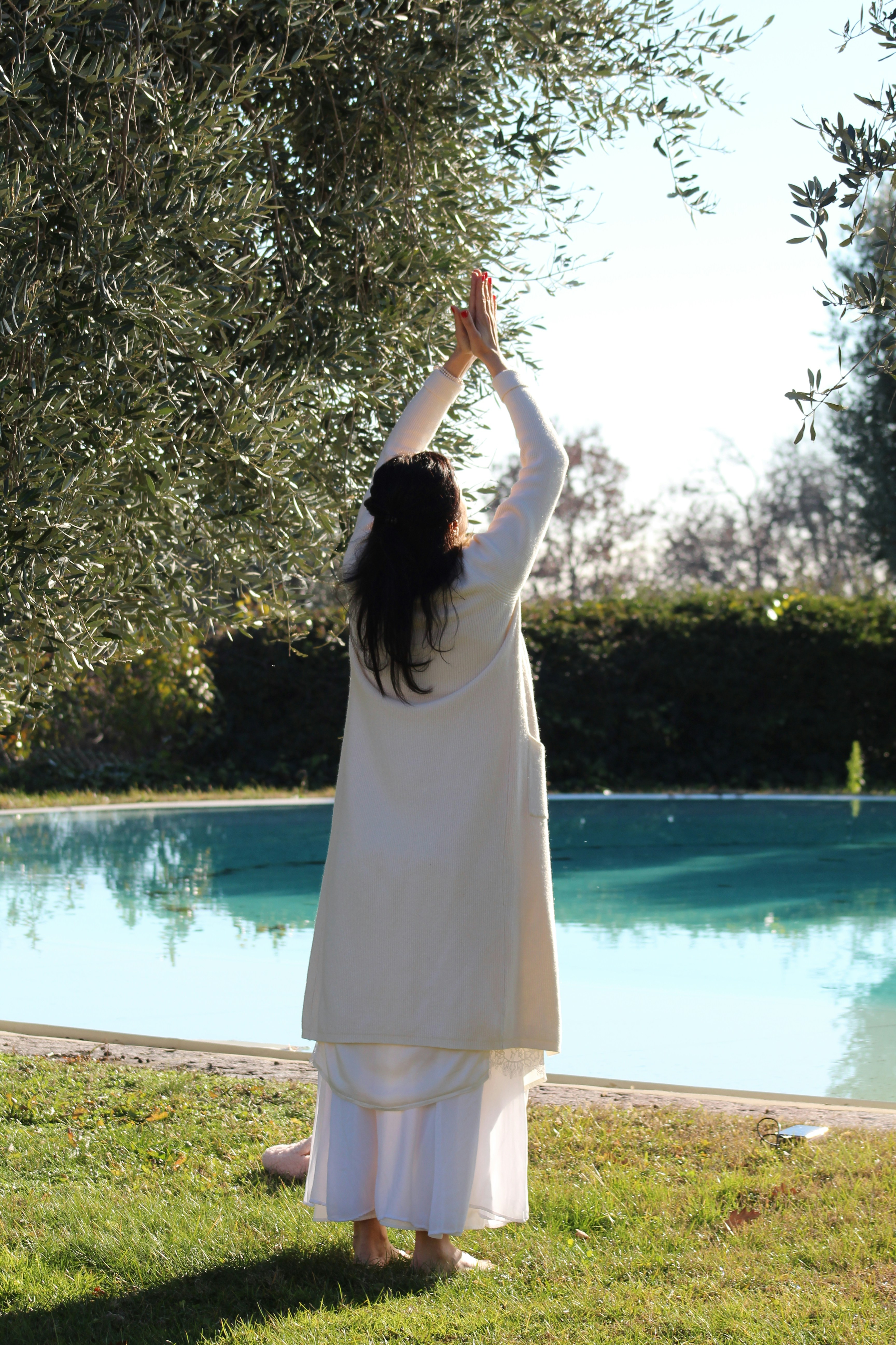 The Zen Moment | Woman practices yoga outdoors by a pool.