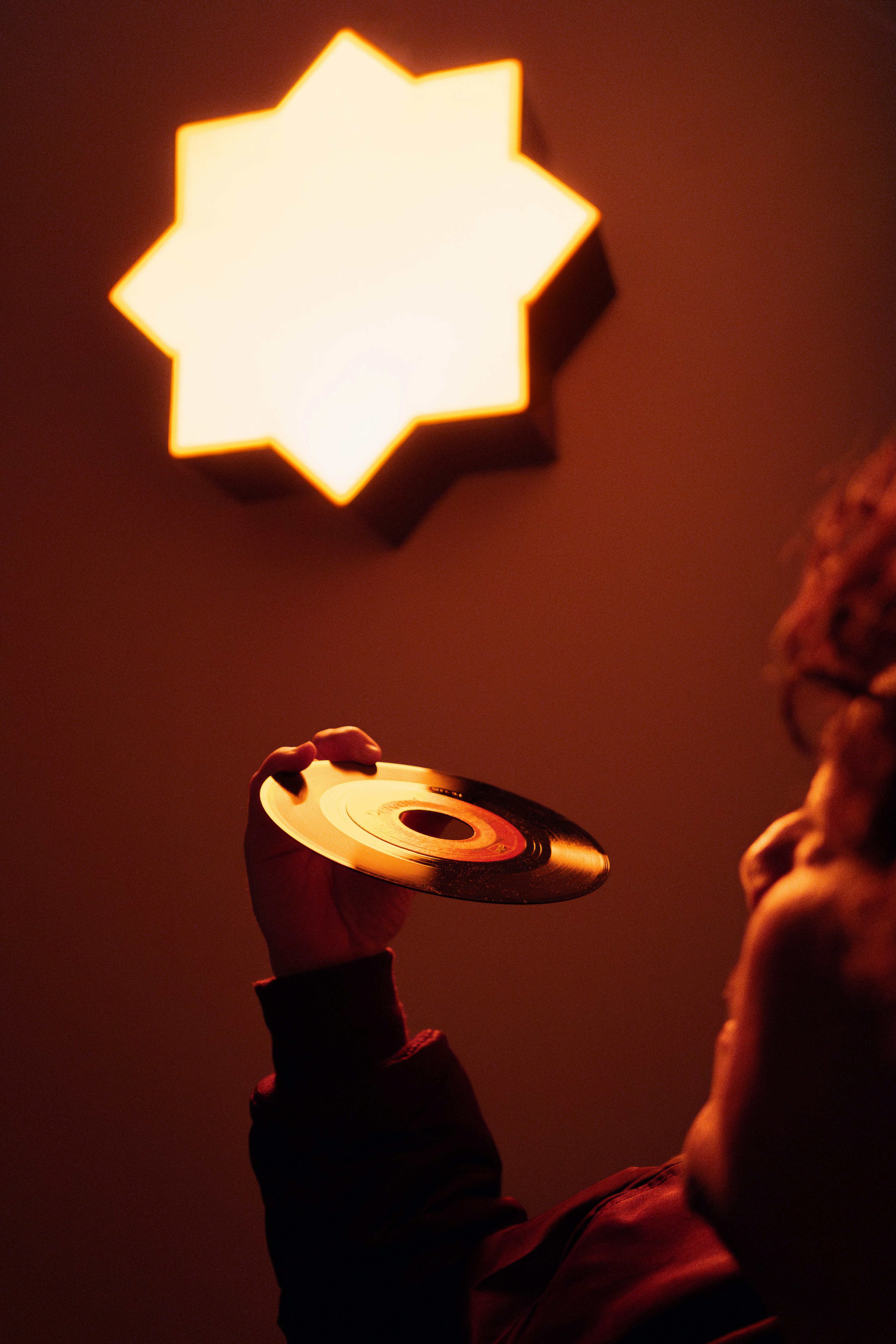 A person is holding a cd under a star-shaped light. photo – Free Music ...