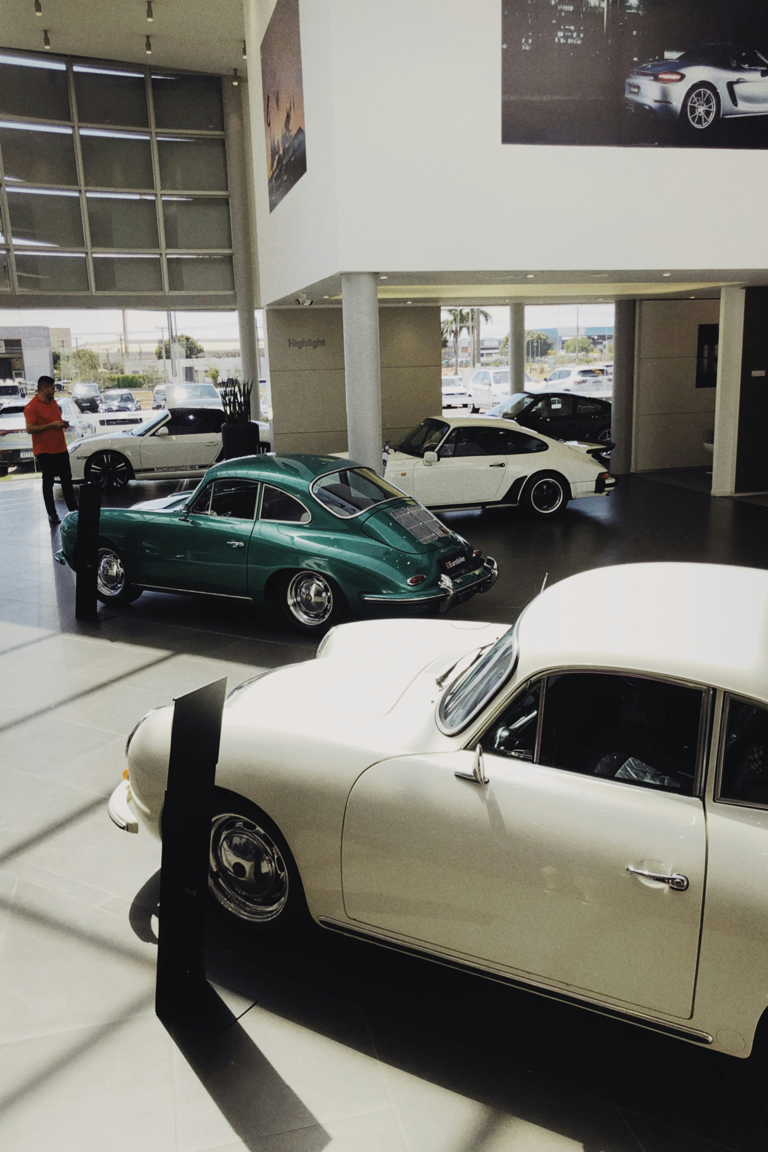 Green Porsche Amid Classic White and Night-blue Showroom Light