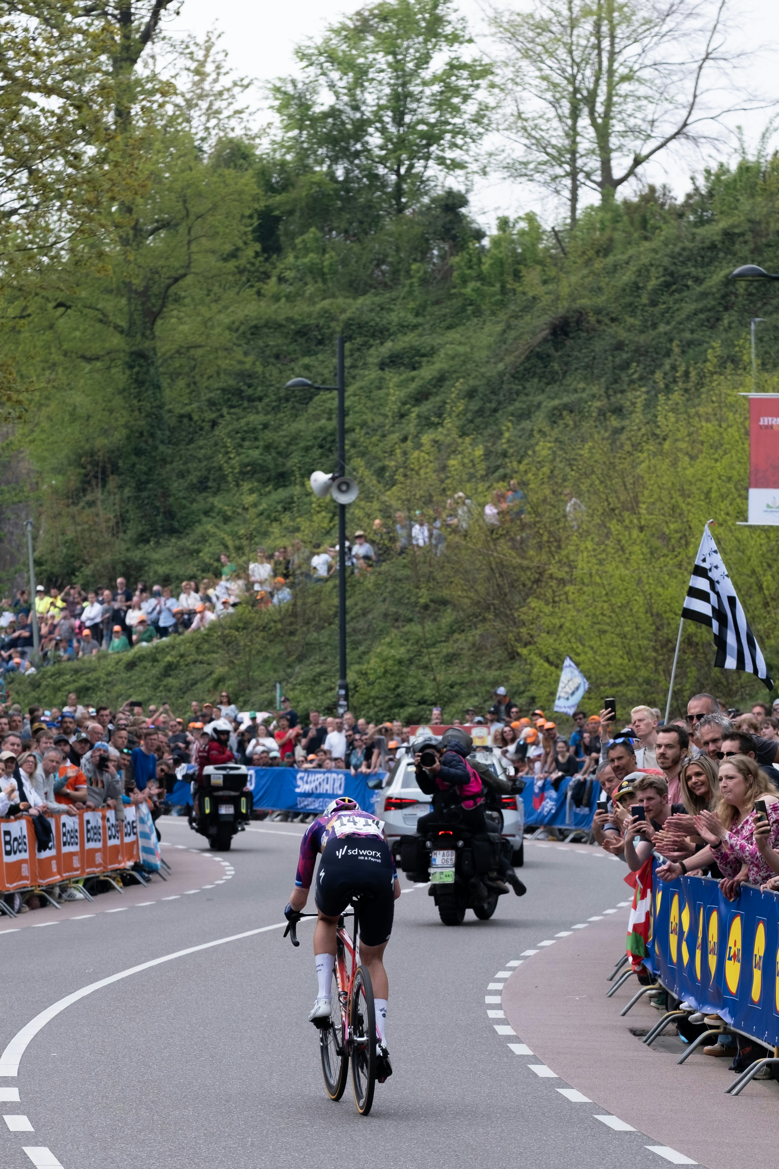 A cyclist races ahead with a crowd of spectators. photo – Free Cycling ...
