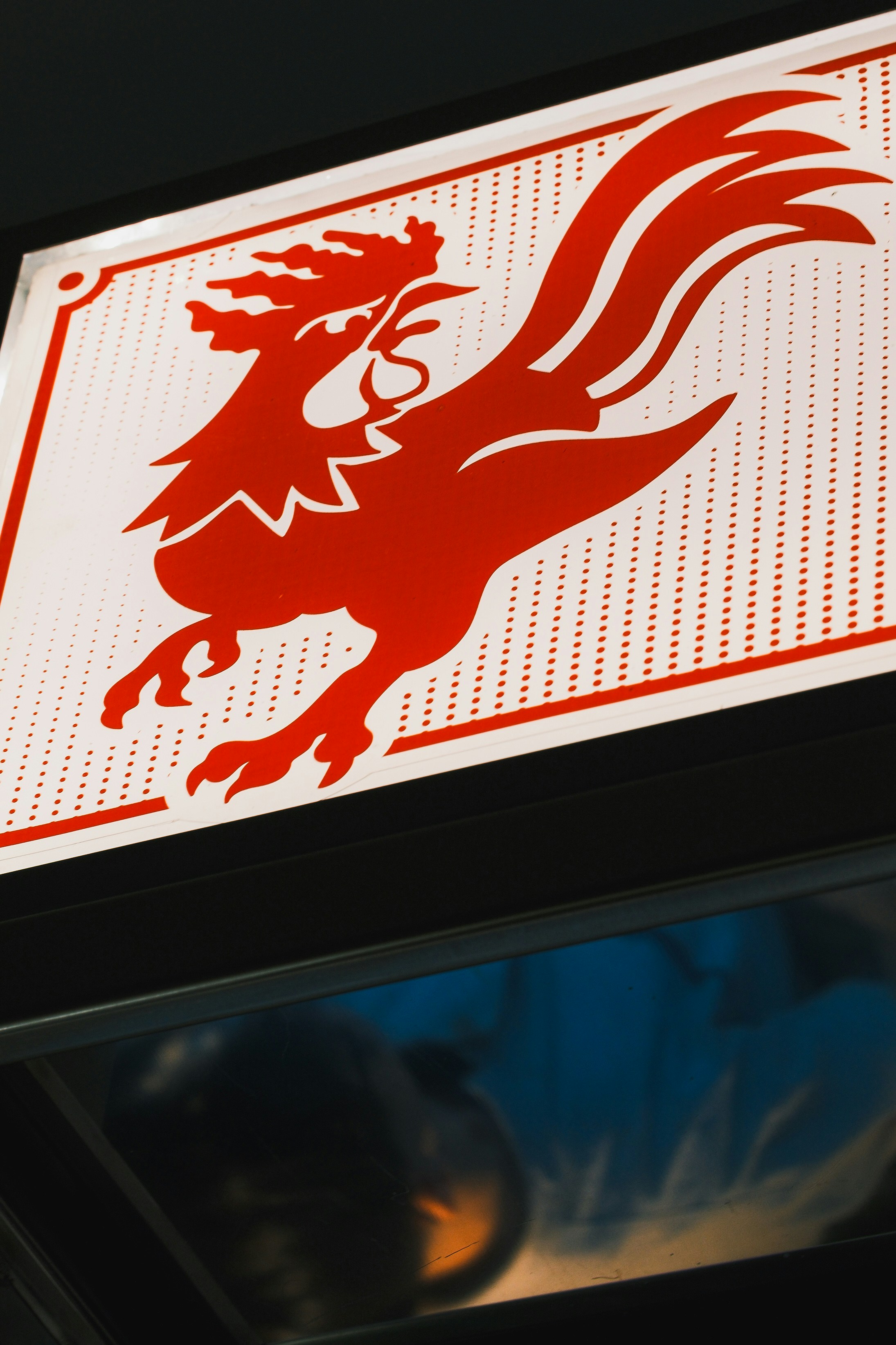 Crimson Rooster Sign: A Bold Silhouette in Evening Light