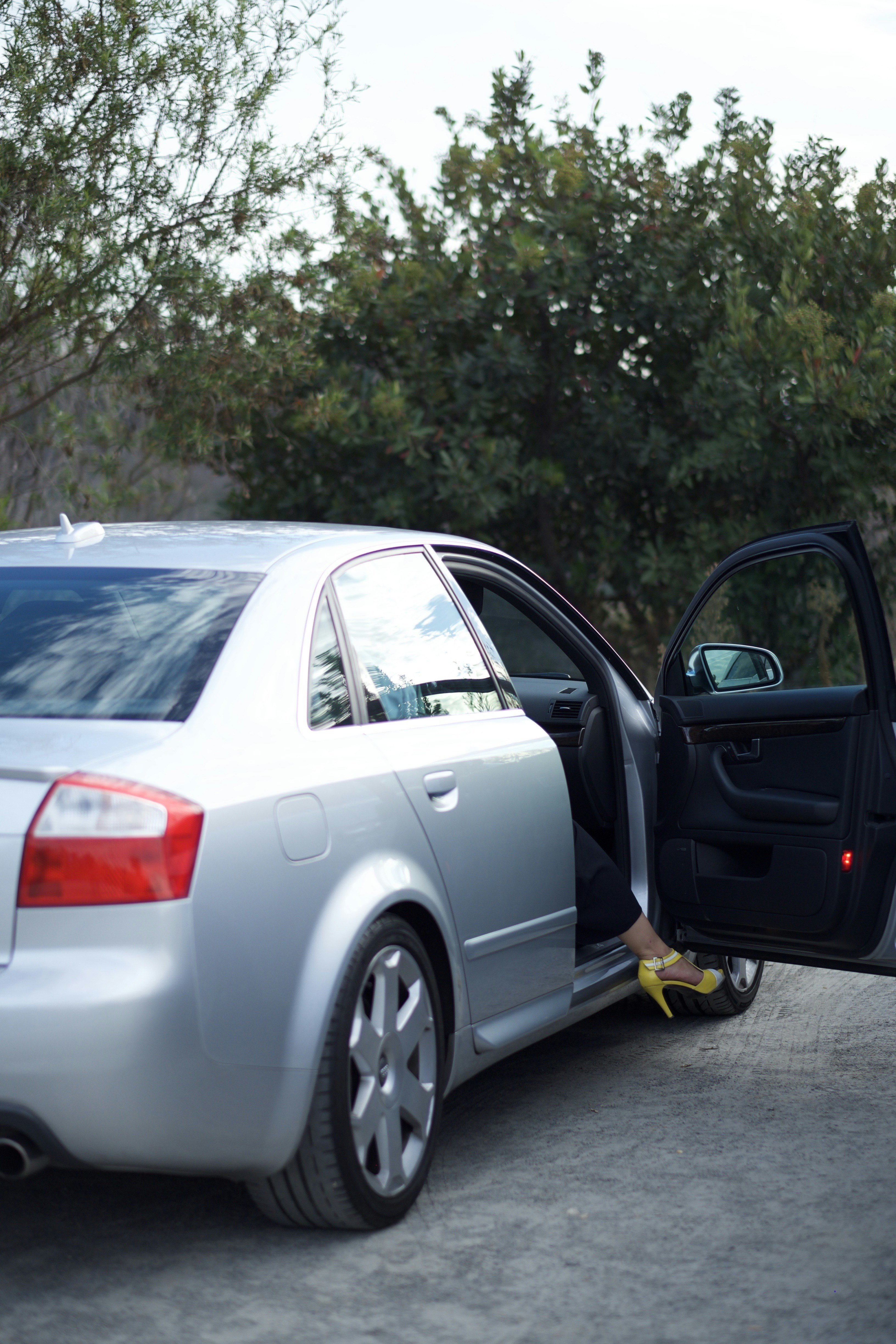 Yellow Heel at the Car Door: A Quiet Moment by the Silver Sedan