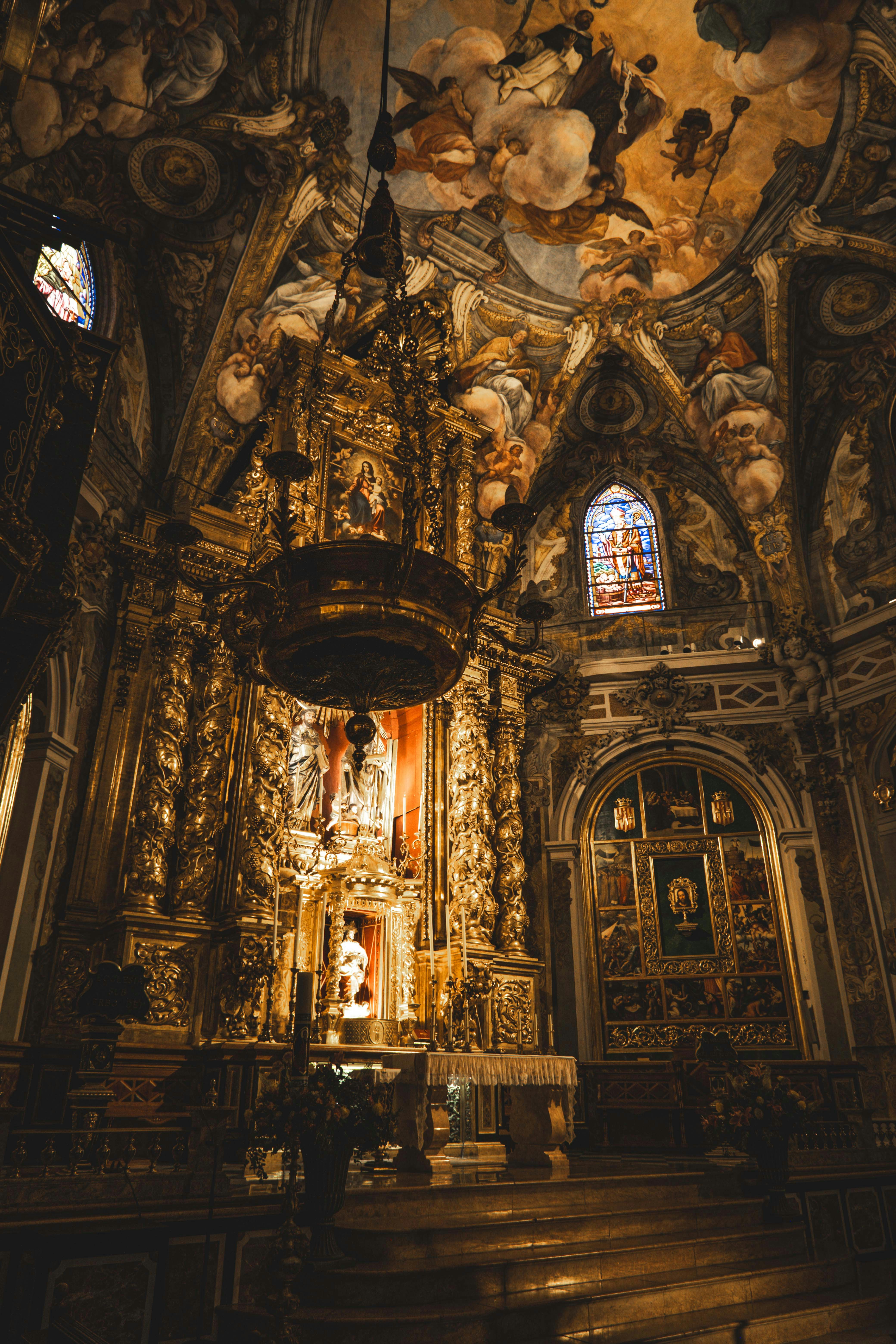 Intricate altar adorned with golden details and religious sculptures, illuminated by warm light in a historic church interior.
