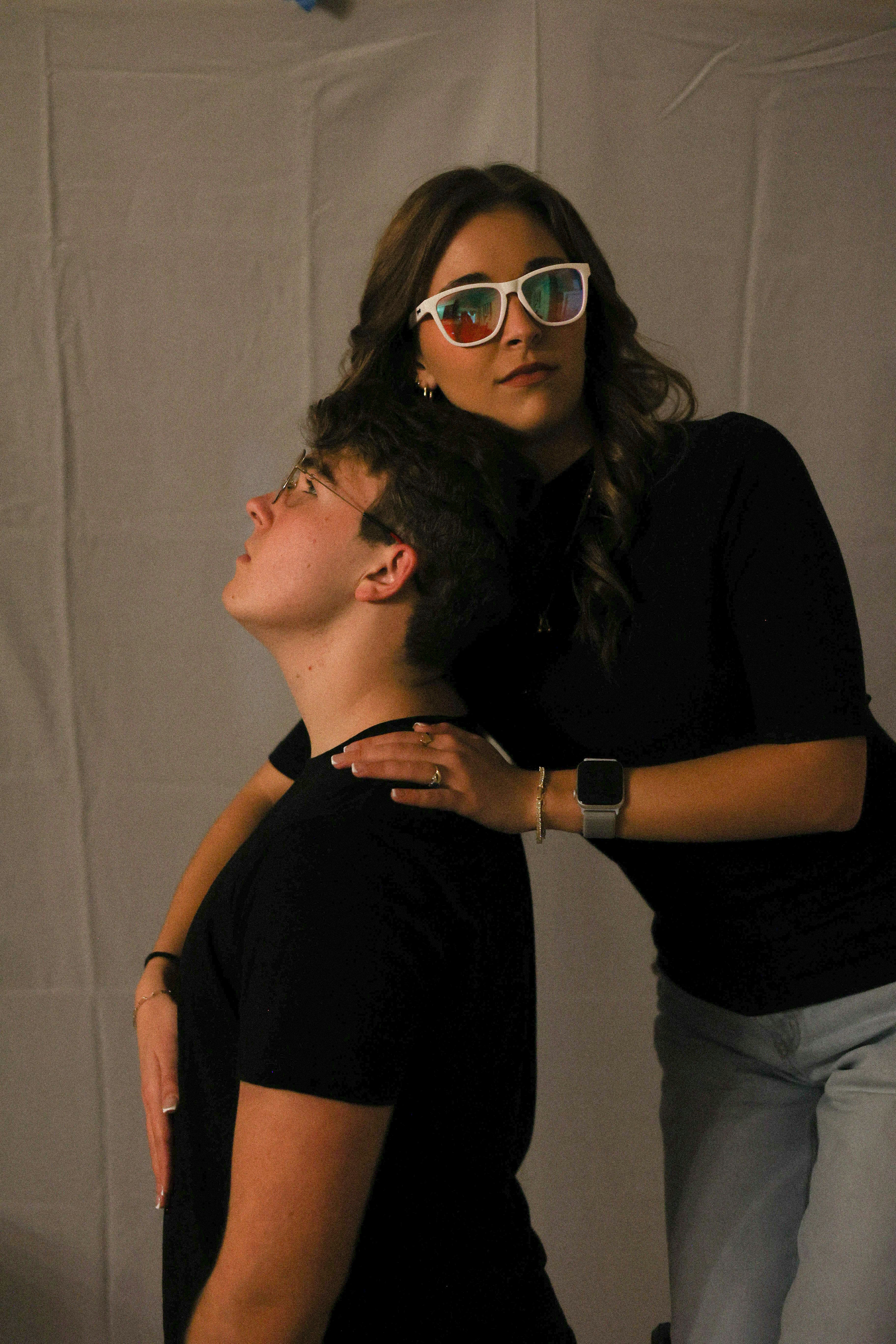 Two friends share a quiet moment in a studio backdrop
