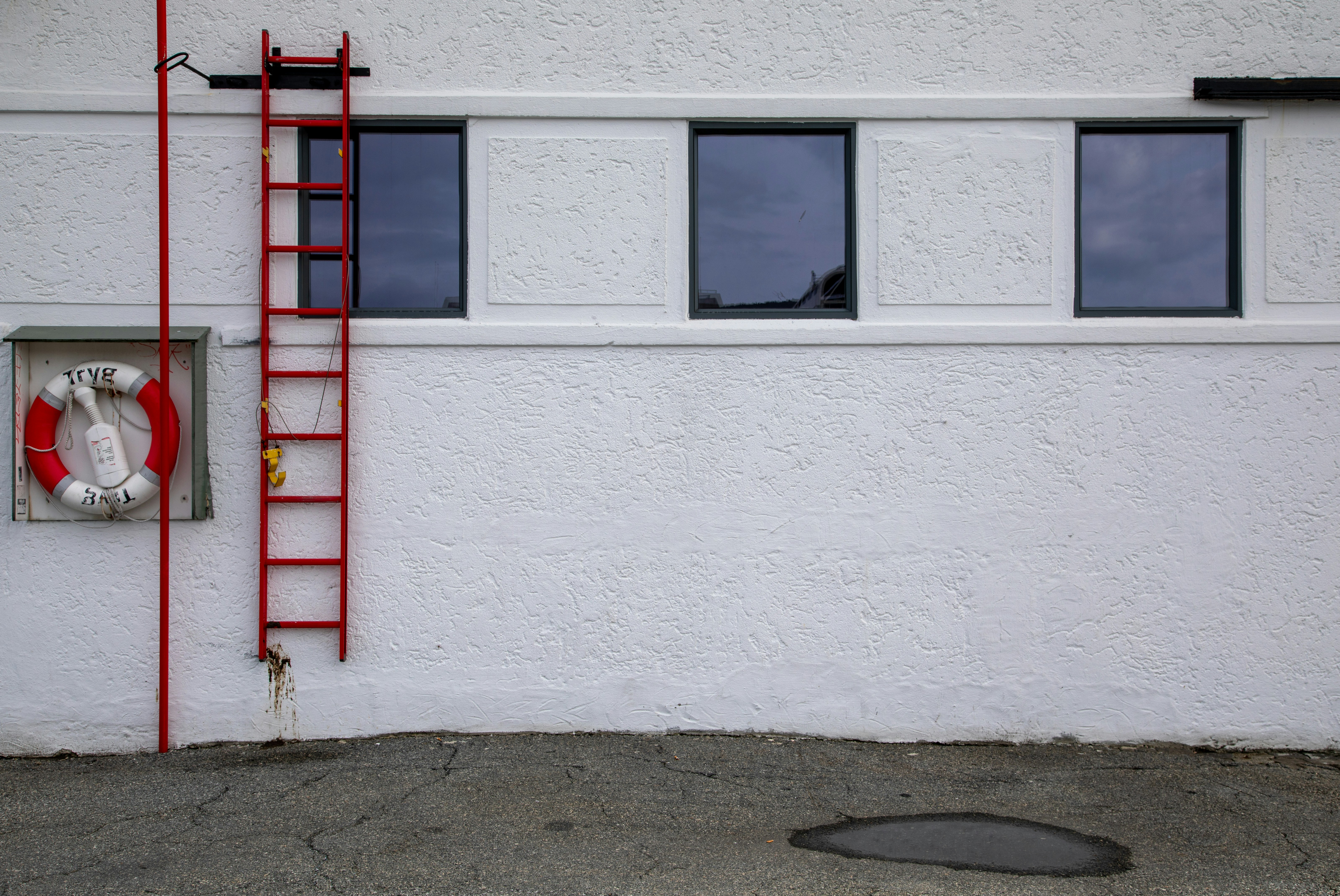 A red ladder and life ring on a white wall. photo – Free Wall Image on ...