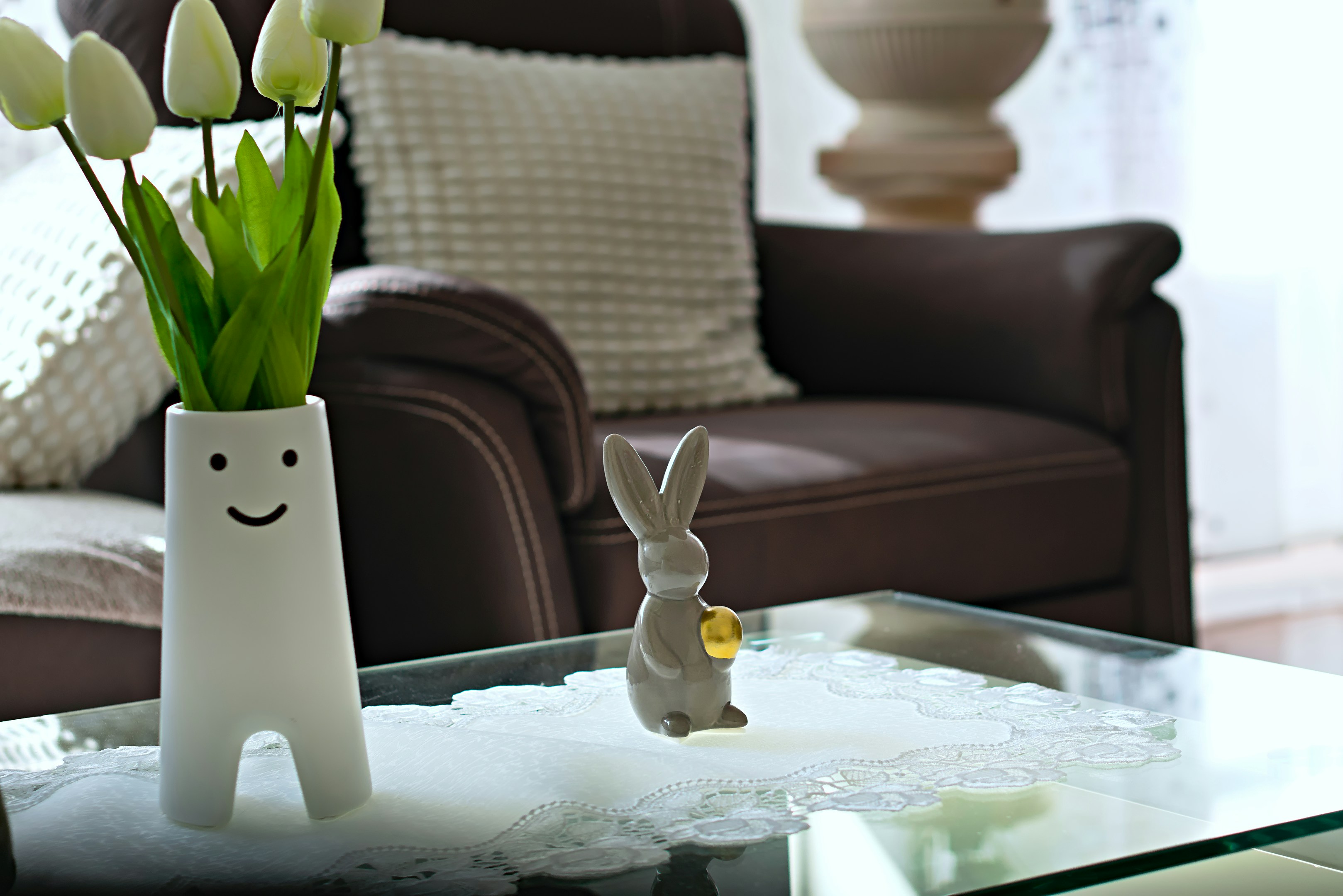 Whimsy on Glass: A White Smiling Vase, Tulips, and a Tiny Bunny