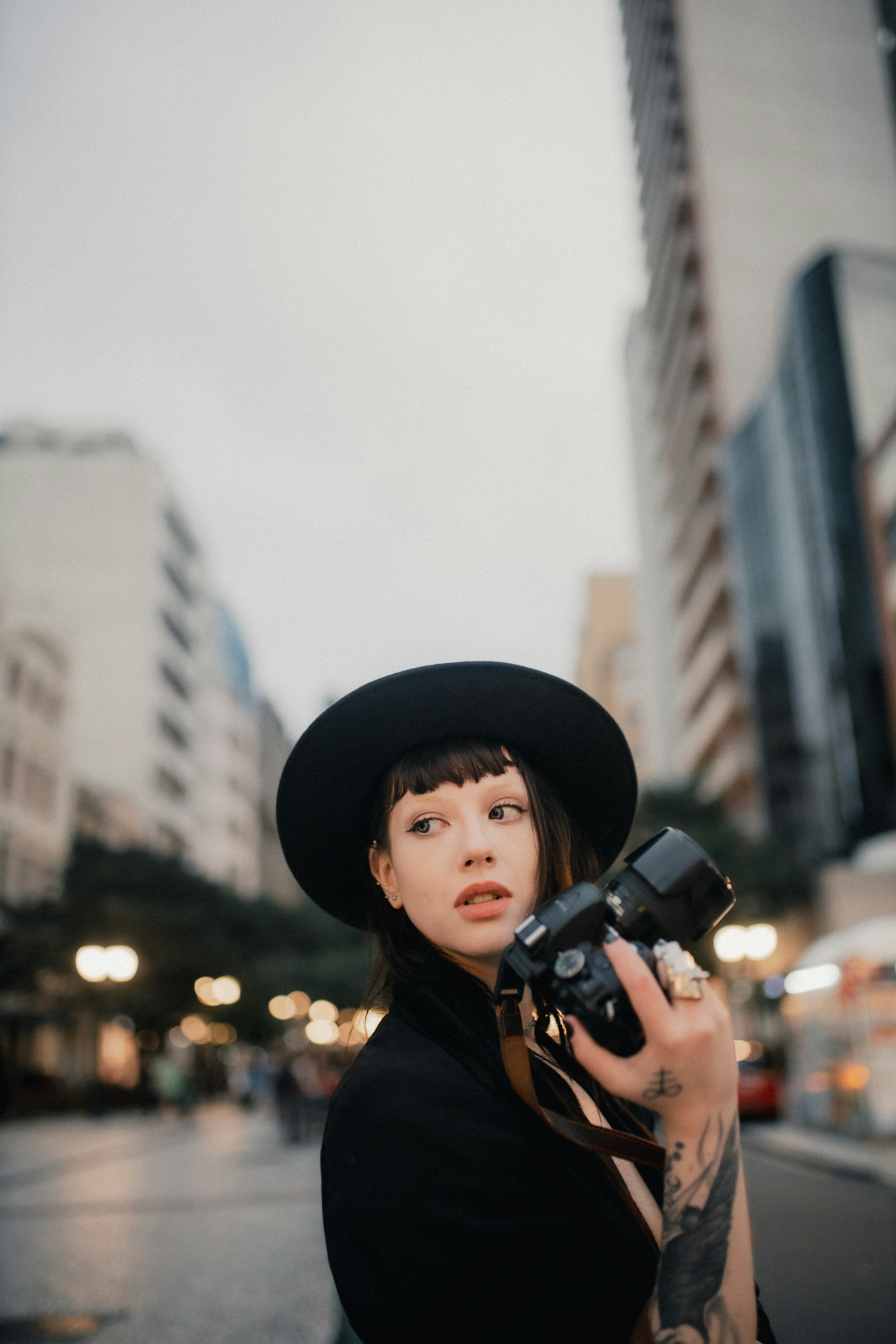Woman in hat holds a camera in the city. photo – Free Image on Unsplash