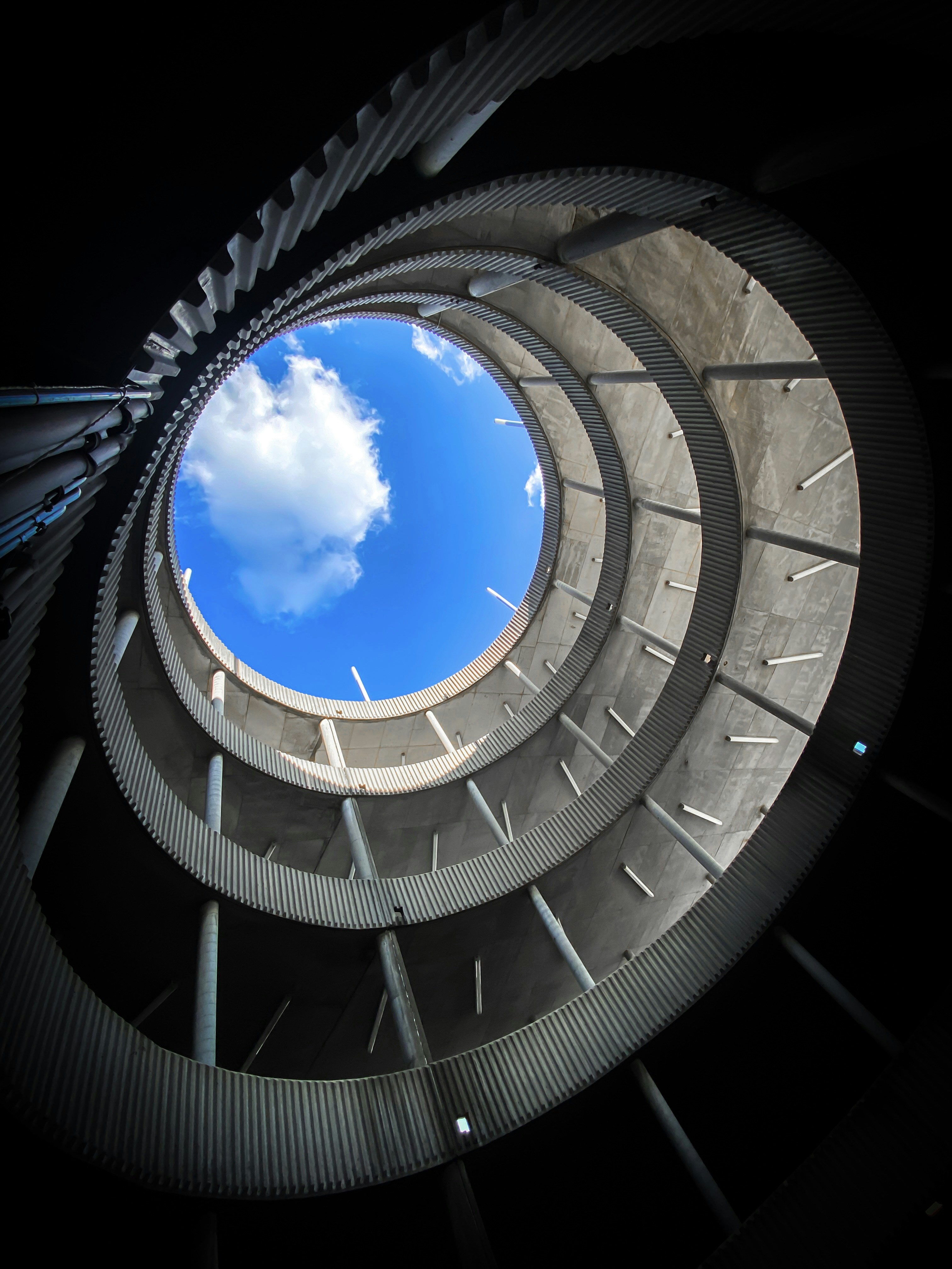 Skyward Spiral: A Concrete Atrium Framing the Blue