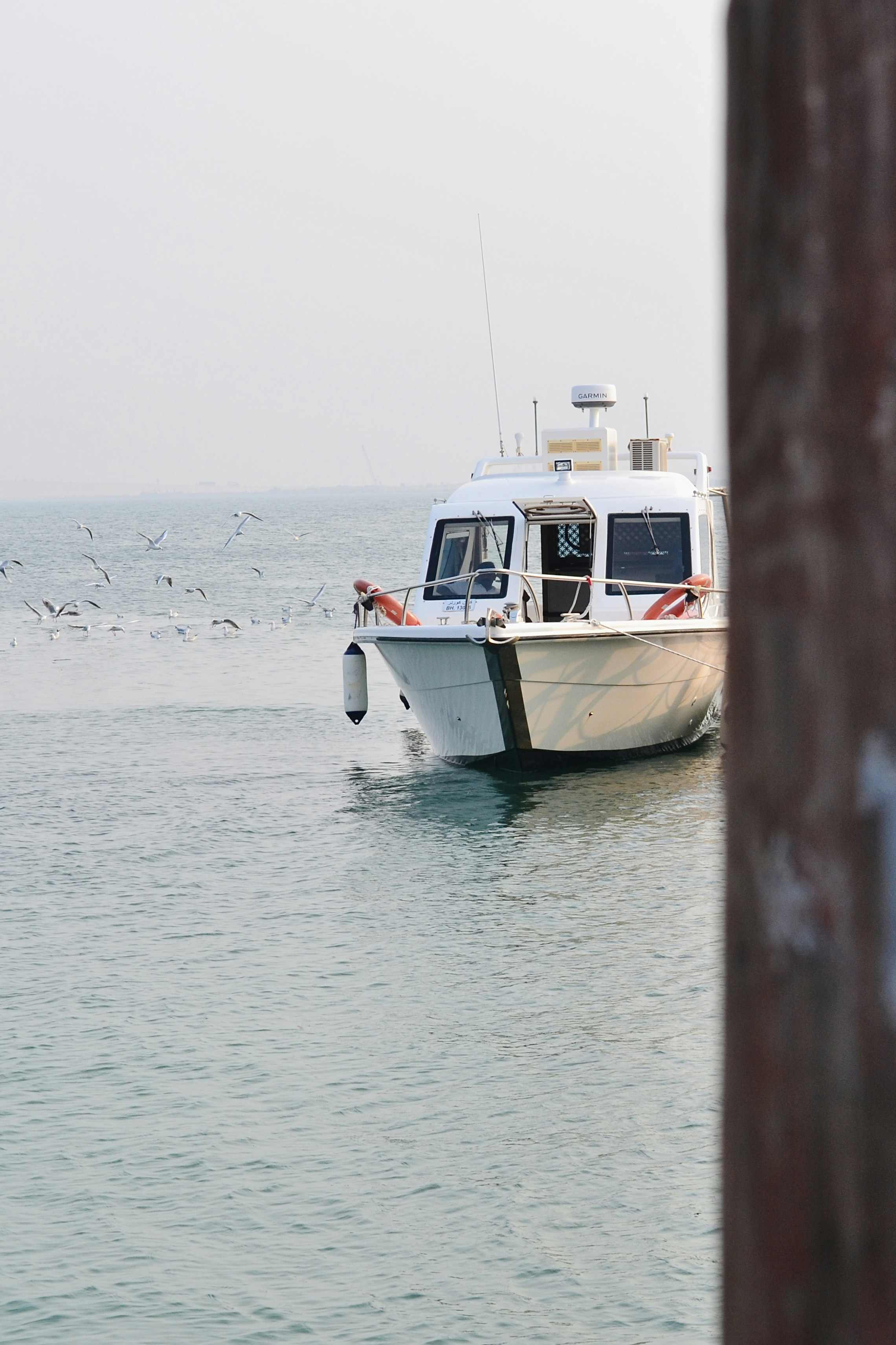 Harbor Quietude: White Motorboat Framed by Weathered Wood