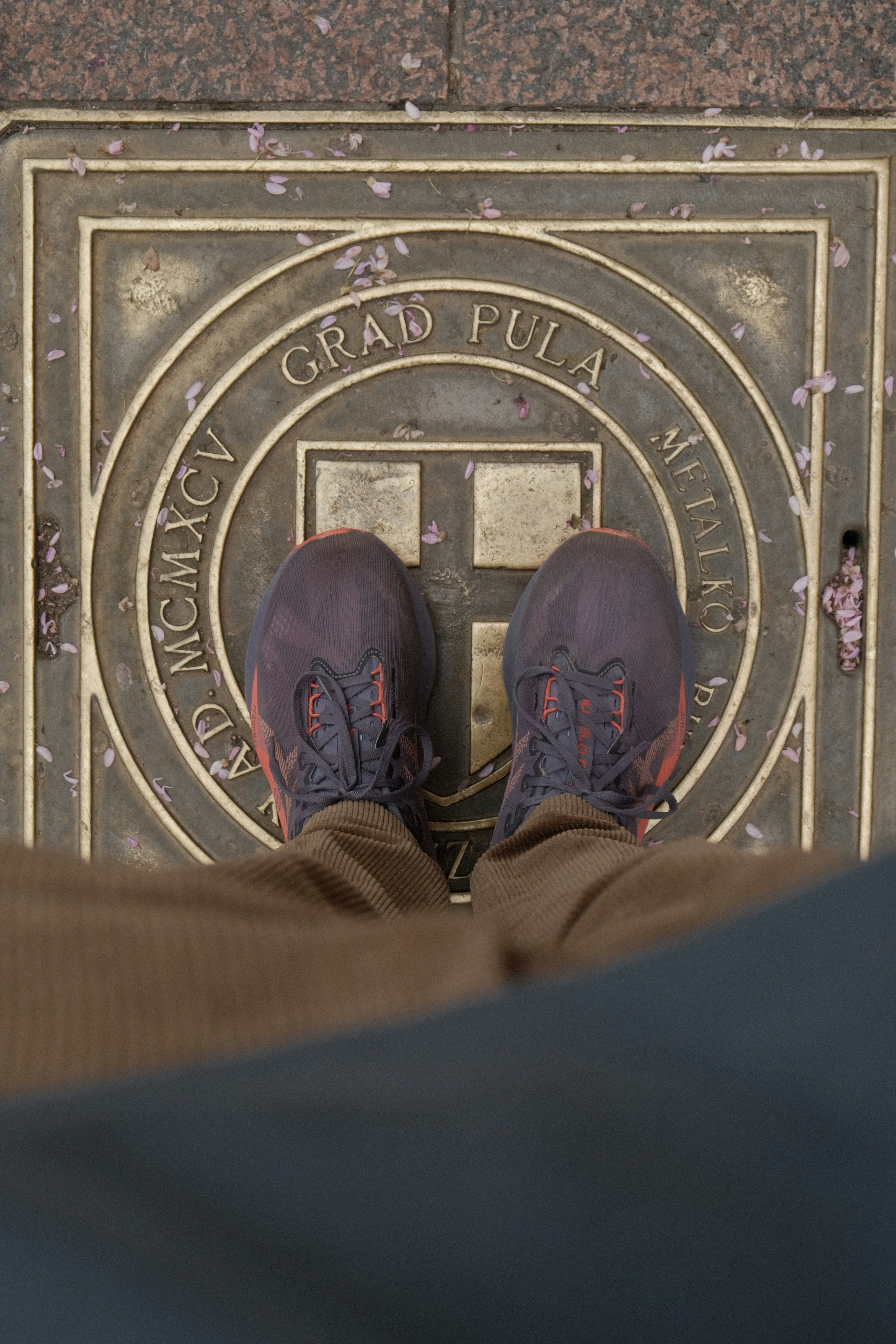 Standpoint Over a City Crest: Boots on a Metro Manhole